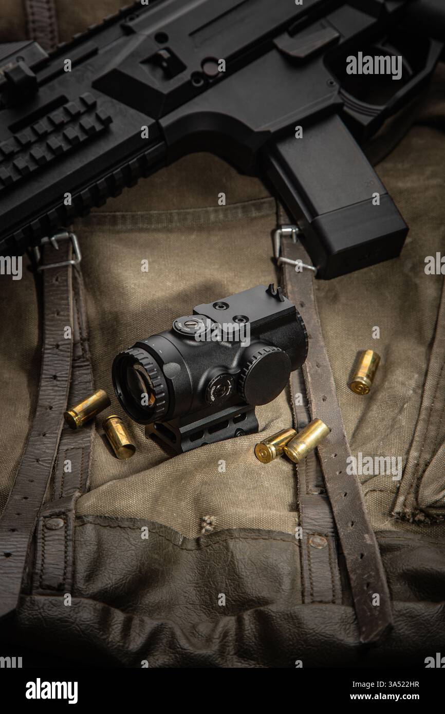 A tactical rifle with a mounted scope and a separate optical sight ...