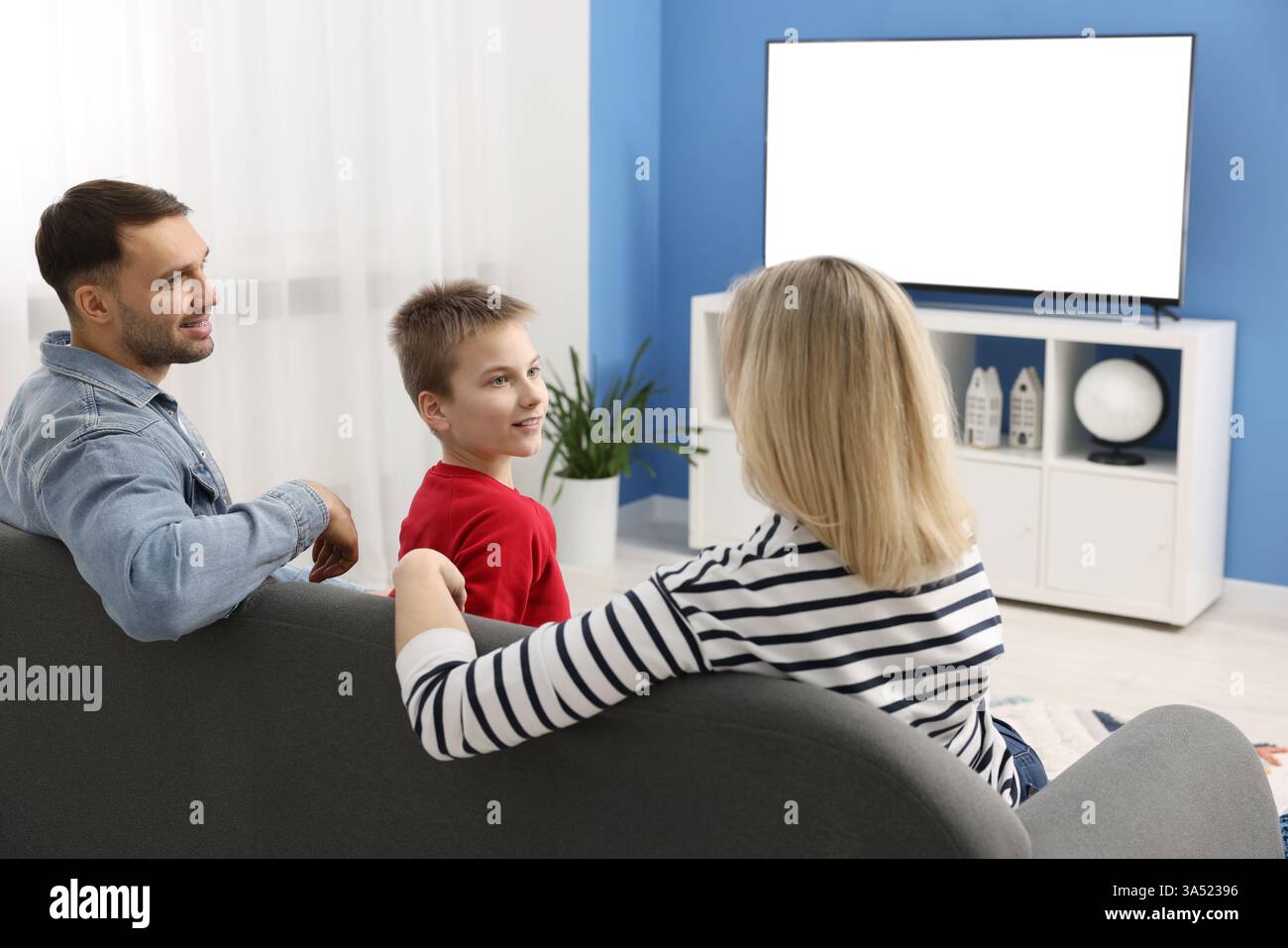 Happy family watching tv together at home Stock Photo - Alamy