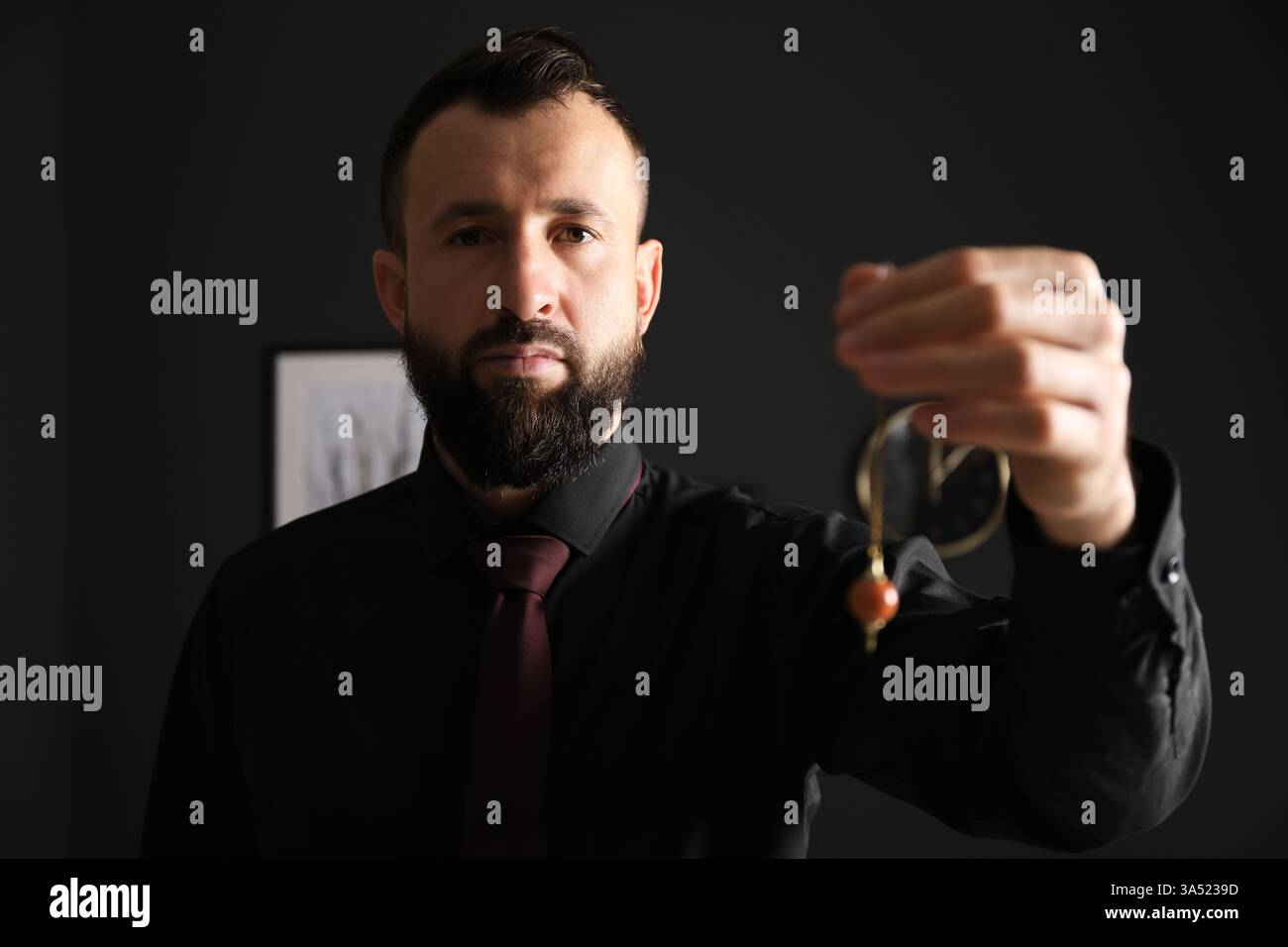 Hypnosis session. Man with pendulum in office Stock Photo - Alamy