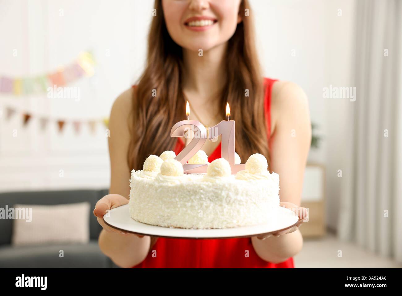 Coming of age party - 21st birthday. Happy young woman holding tasty ...