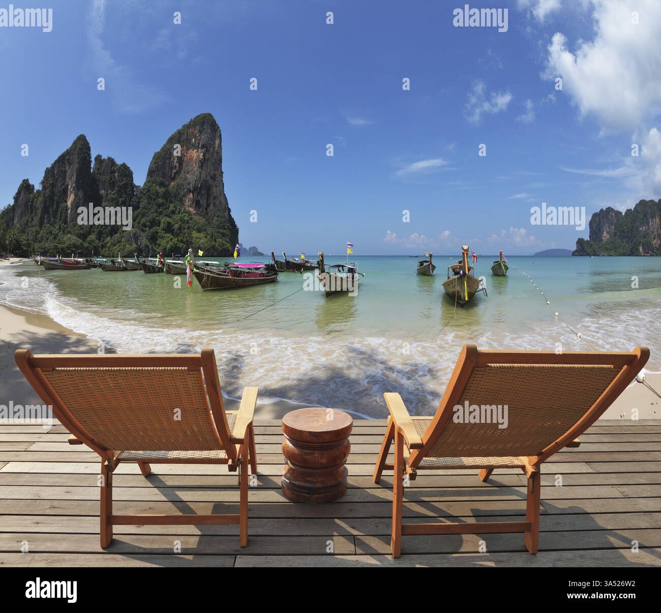 Cozy beach rest. Two wooden chaise lounges and small bedside table on a ...