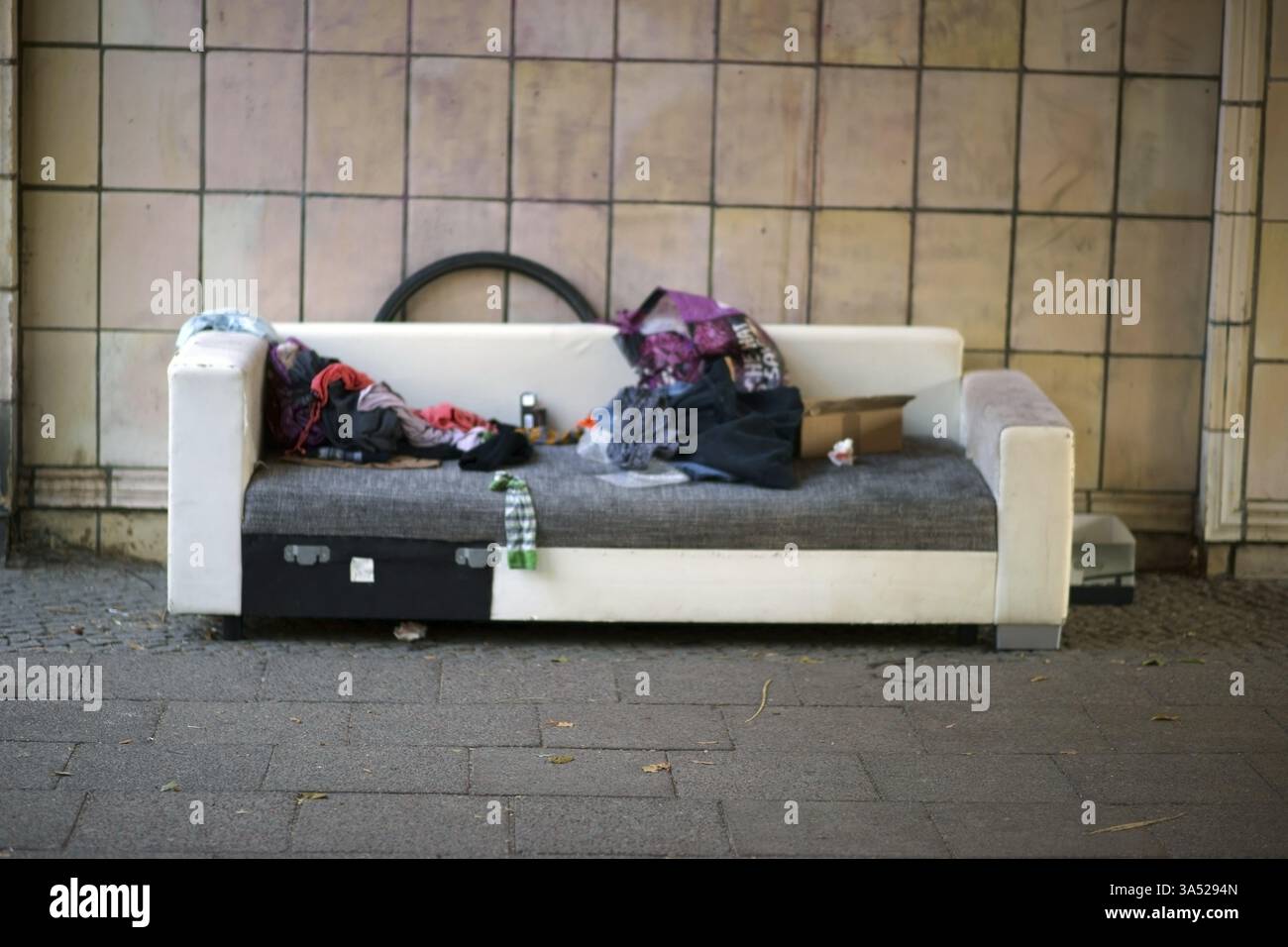 The sleeping place of a homeless person under a bridge with blankets ...
