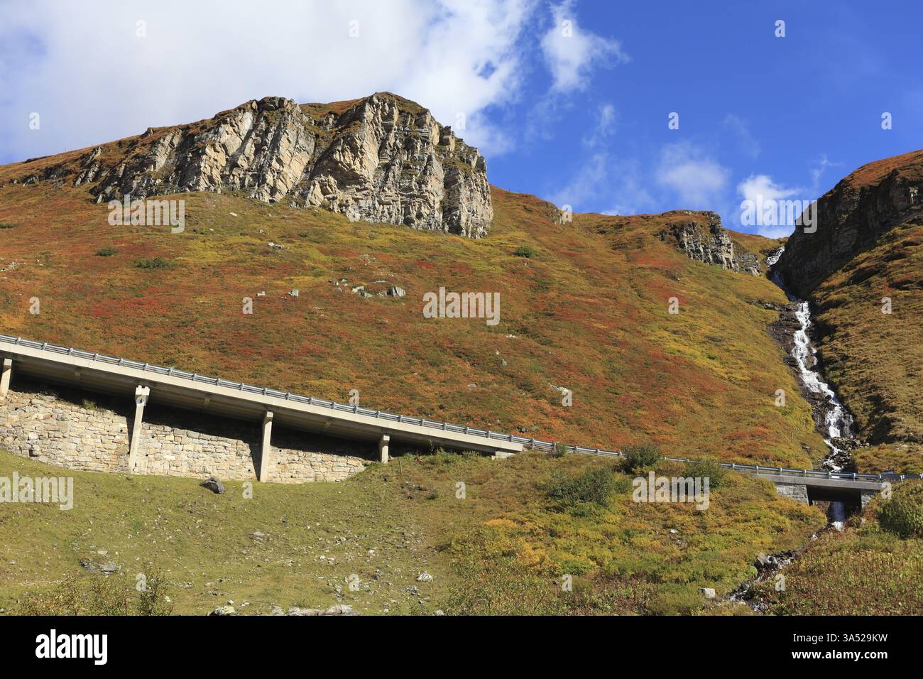 The platform supports and fences the highway. Snow-capped Alps in ...