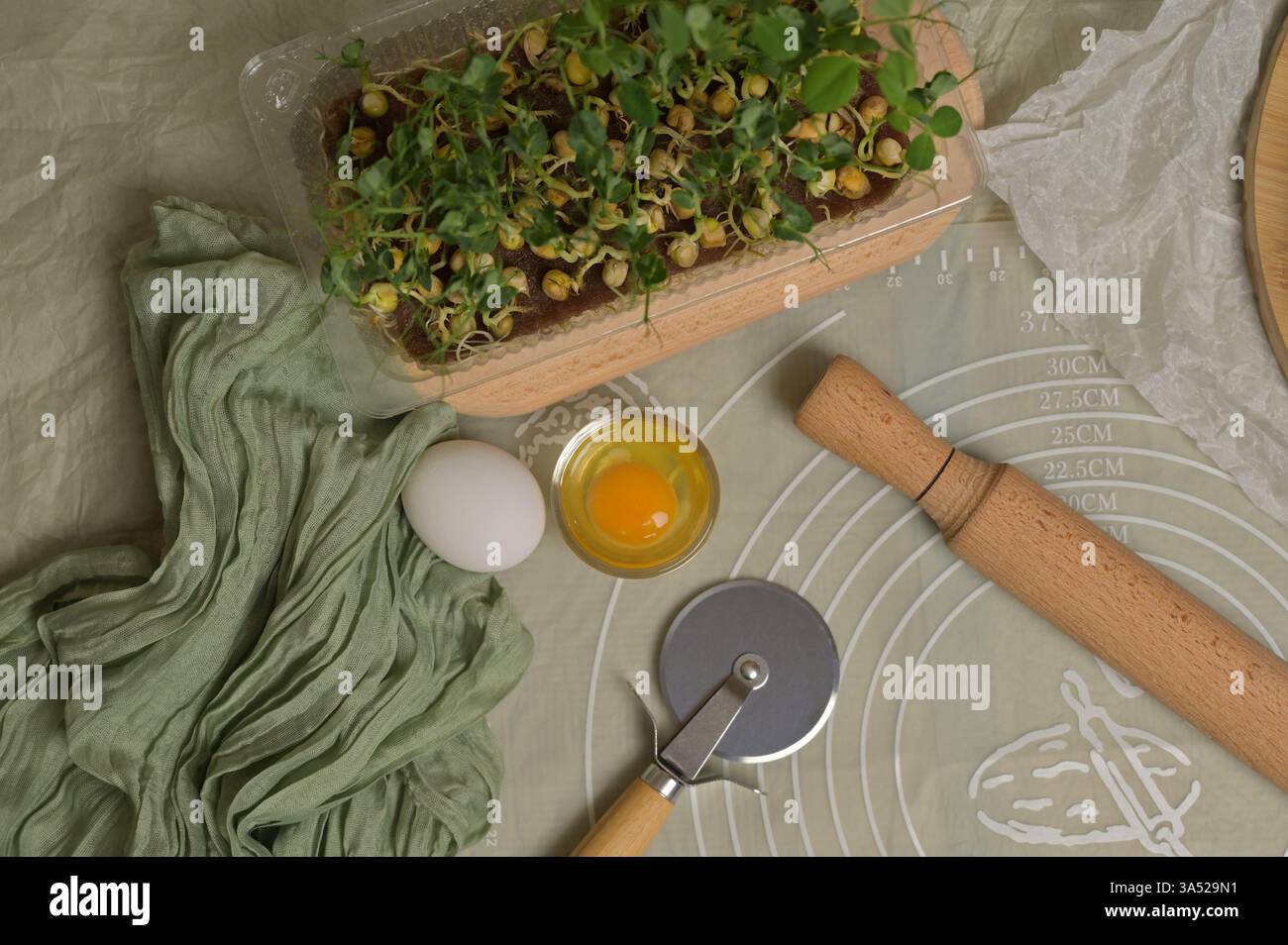 Rolling pin, cutter, eggs and microgreens sprouts on kitchen table ...