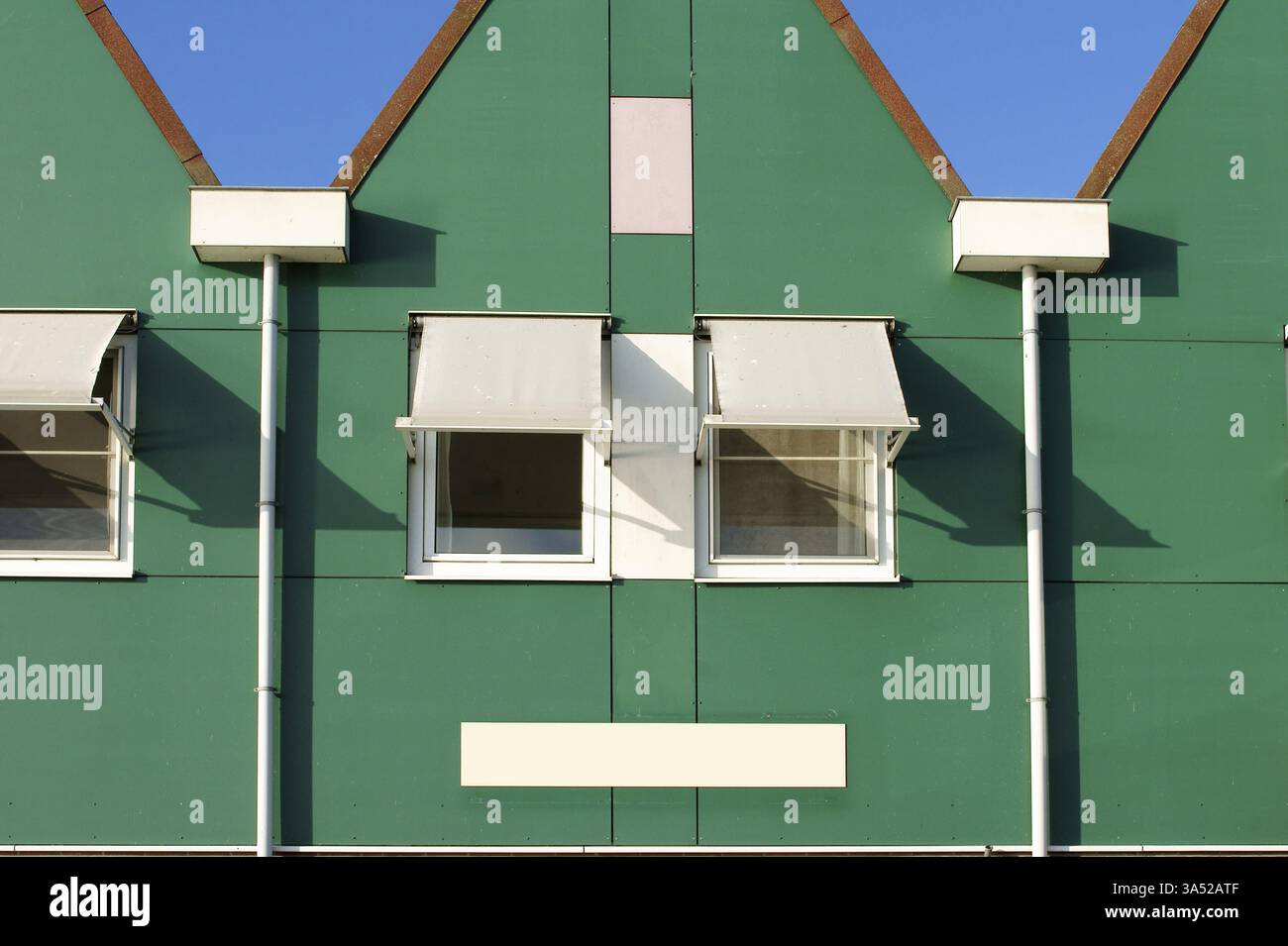 A Dutch house with a triangular roof gable and sun protection in front ...
