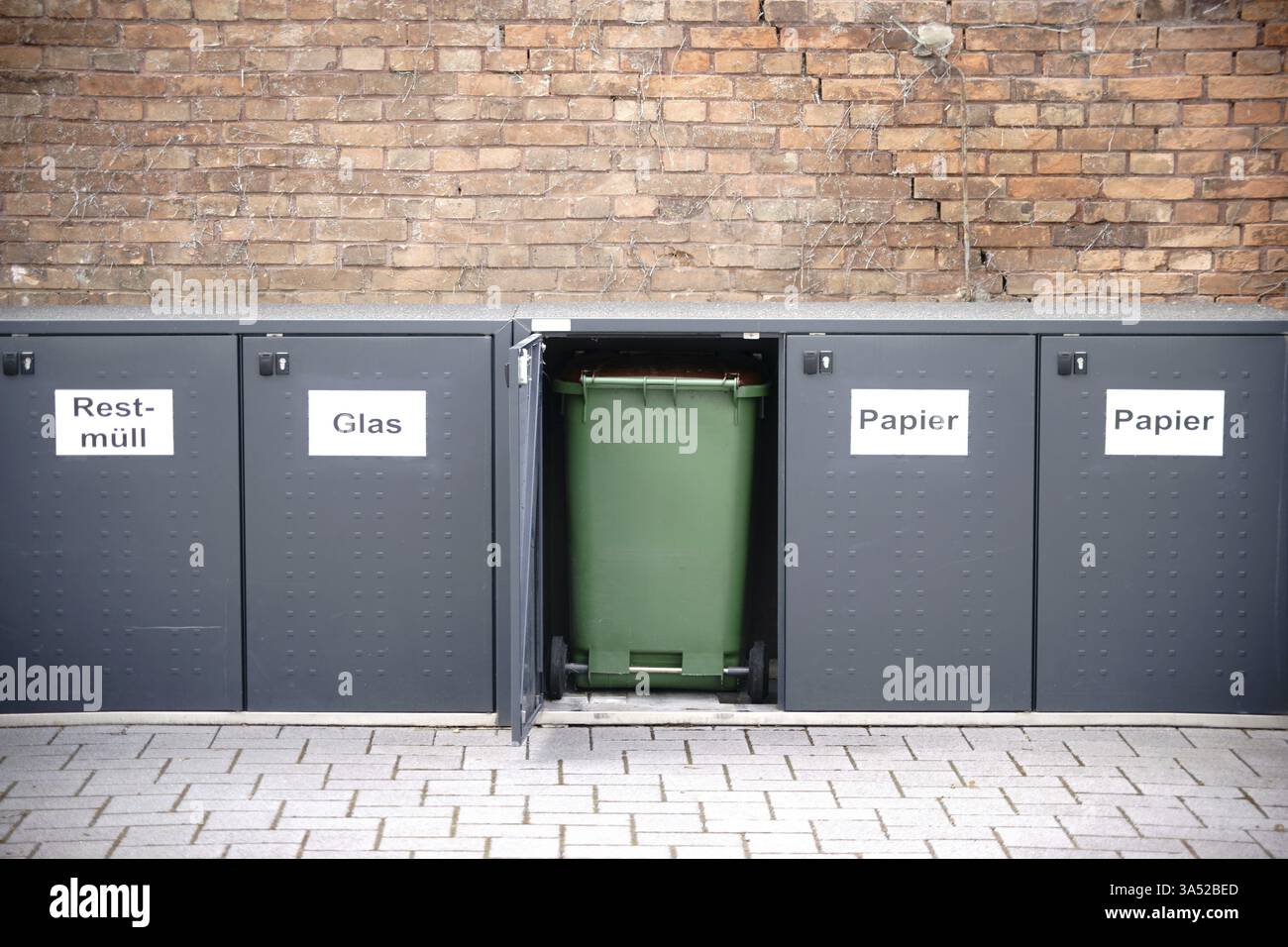 Waste bins are arranged in a row in lockable metal boxes Stock Photo ...