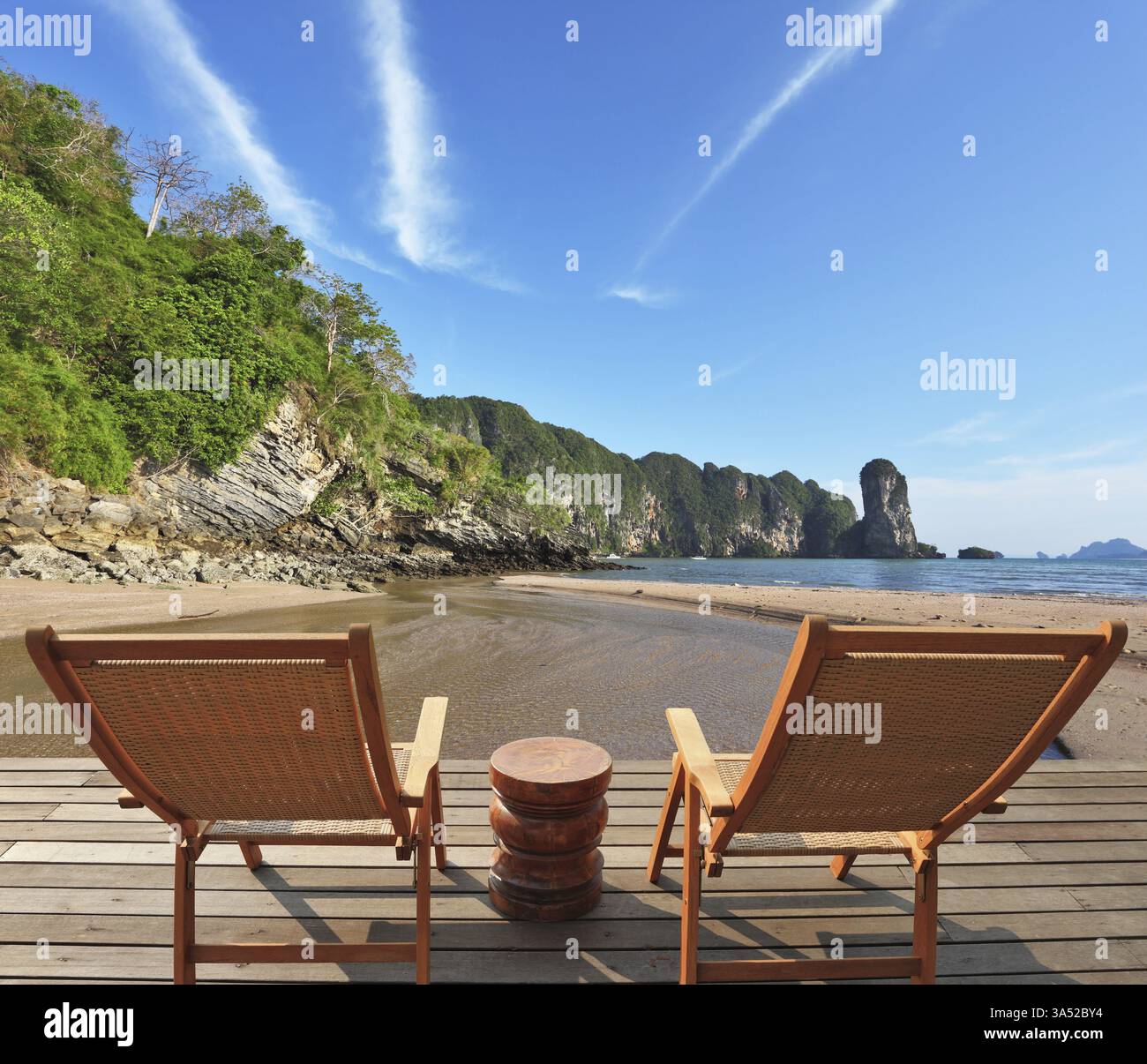 Cozy beach rest. Two wooden chaise lounges and small bedside table ...