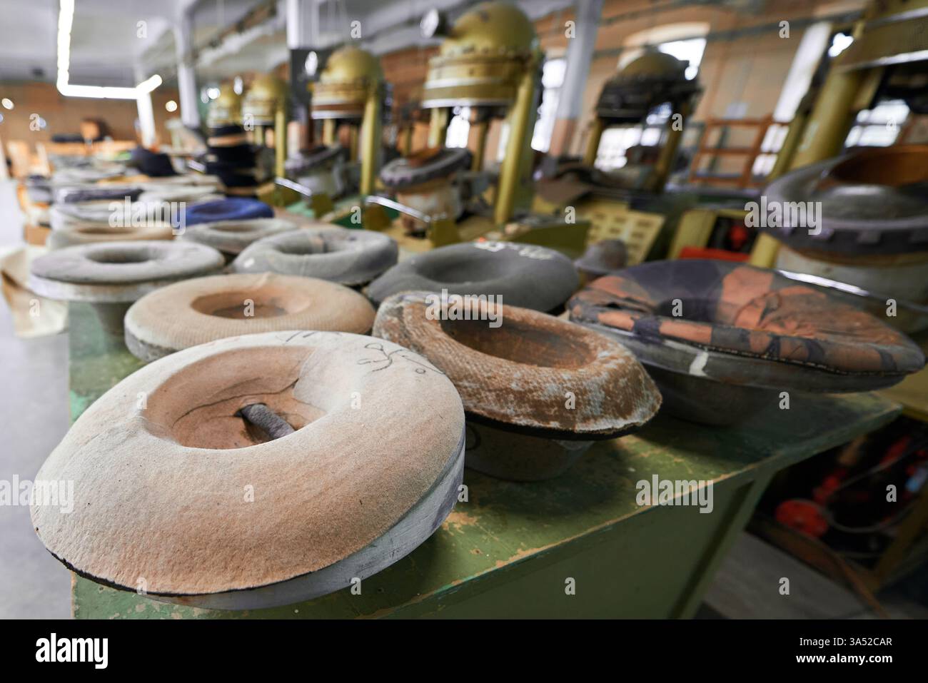 Crafting unique felt hat molds in a bustling workshop filled with ...