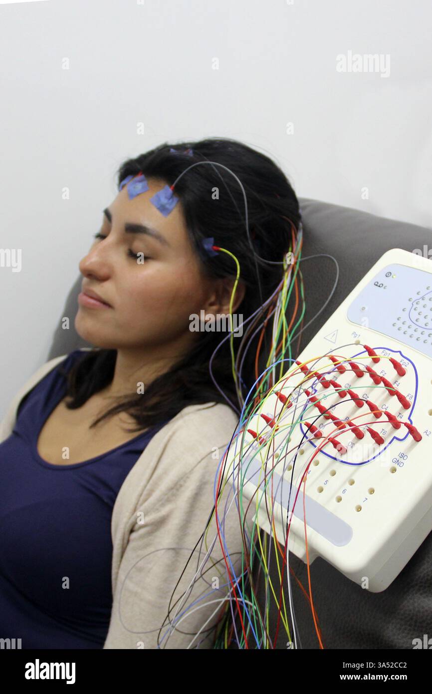 20-year-old Latin brunette woman undergoes EEG electroencephalogram neurological examination ...