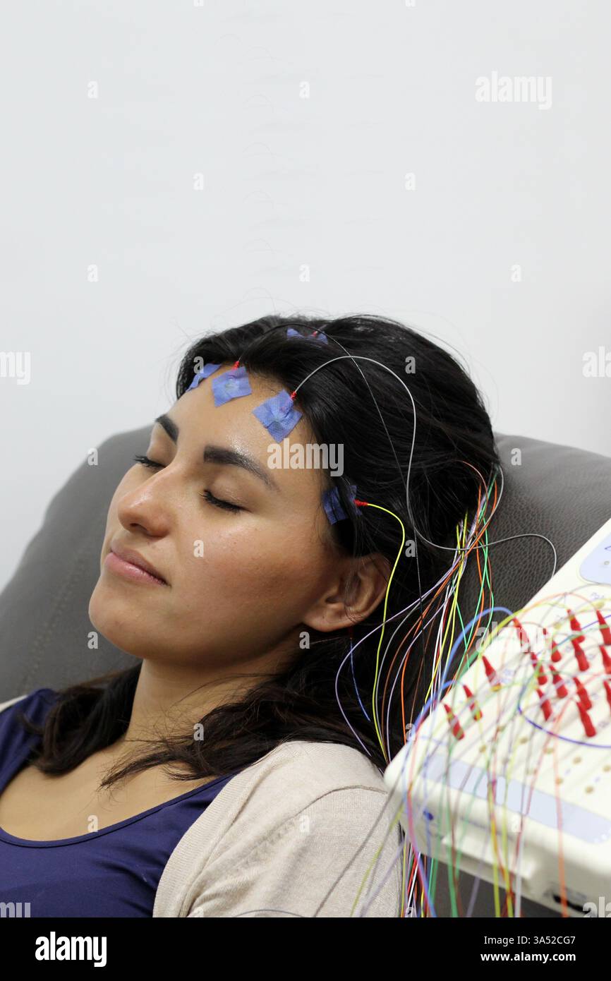 20-year-old Latin brunette woman undergoes EEG electroencephalogram neurological examination ...