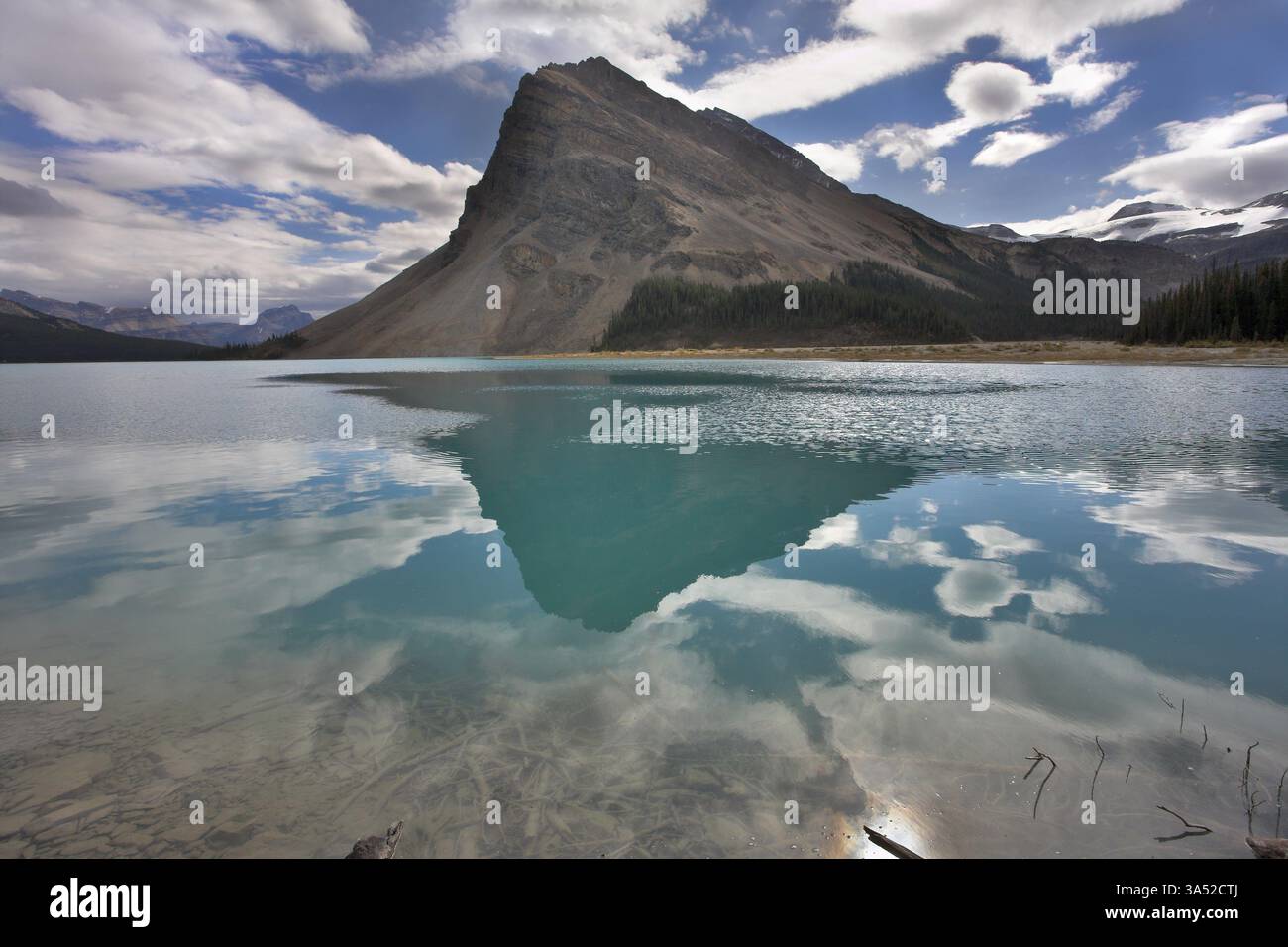 The huge rock of the triangular form is reflected in emerald waters of ...