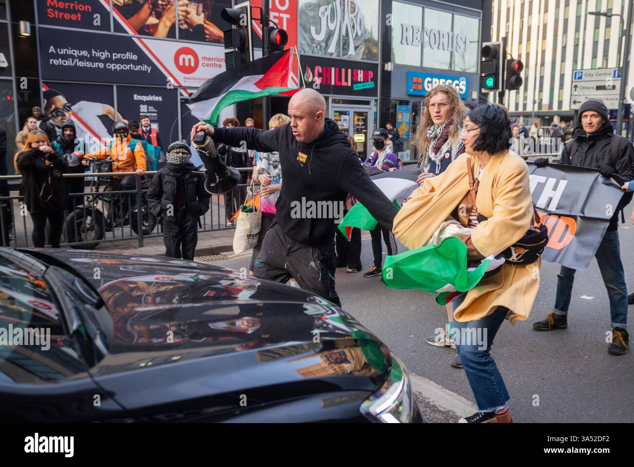 Leeds, UK. 20 MAR, 2025. Man steals a megaphone as protestors from ...