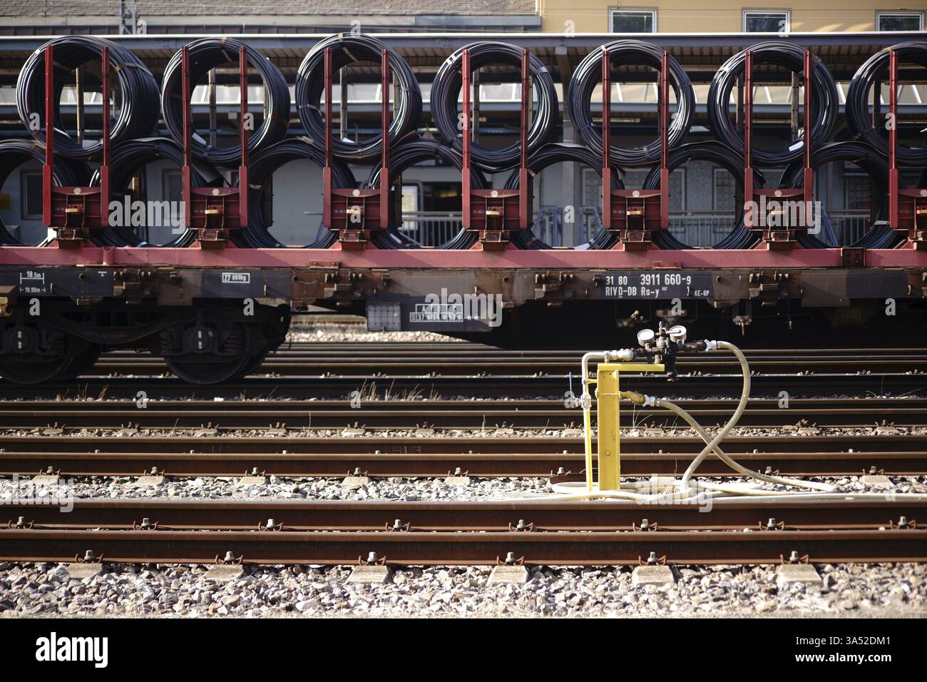 The side view of the railway wagons of a goods train loaded with cables ...