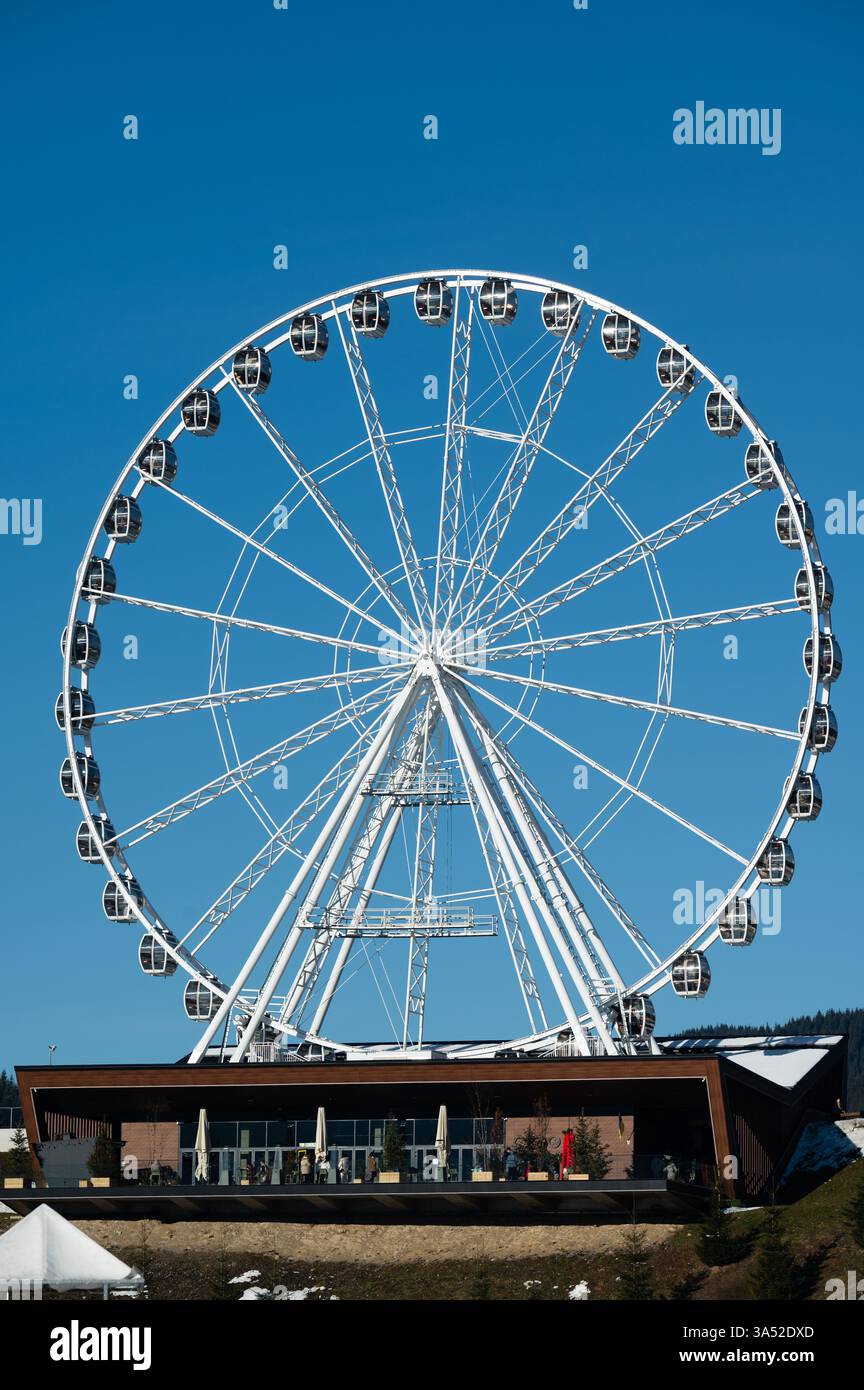 Visitors admire the impressive structure of a giant observation wheel ...