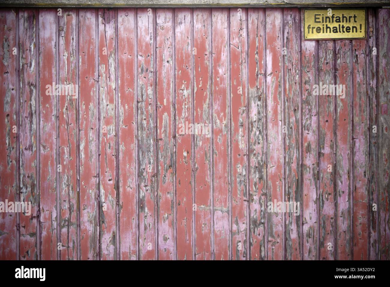 A heavily worn wooden gate with a yellow sign: Keep exit clear Stock ...
