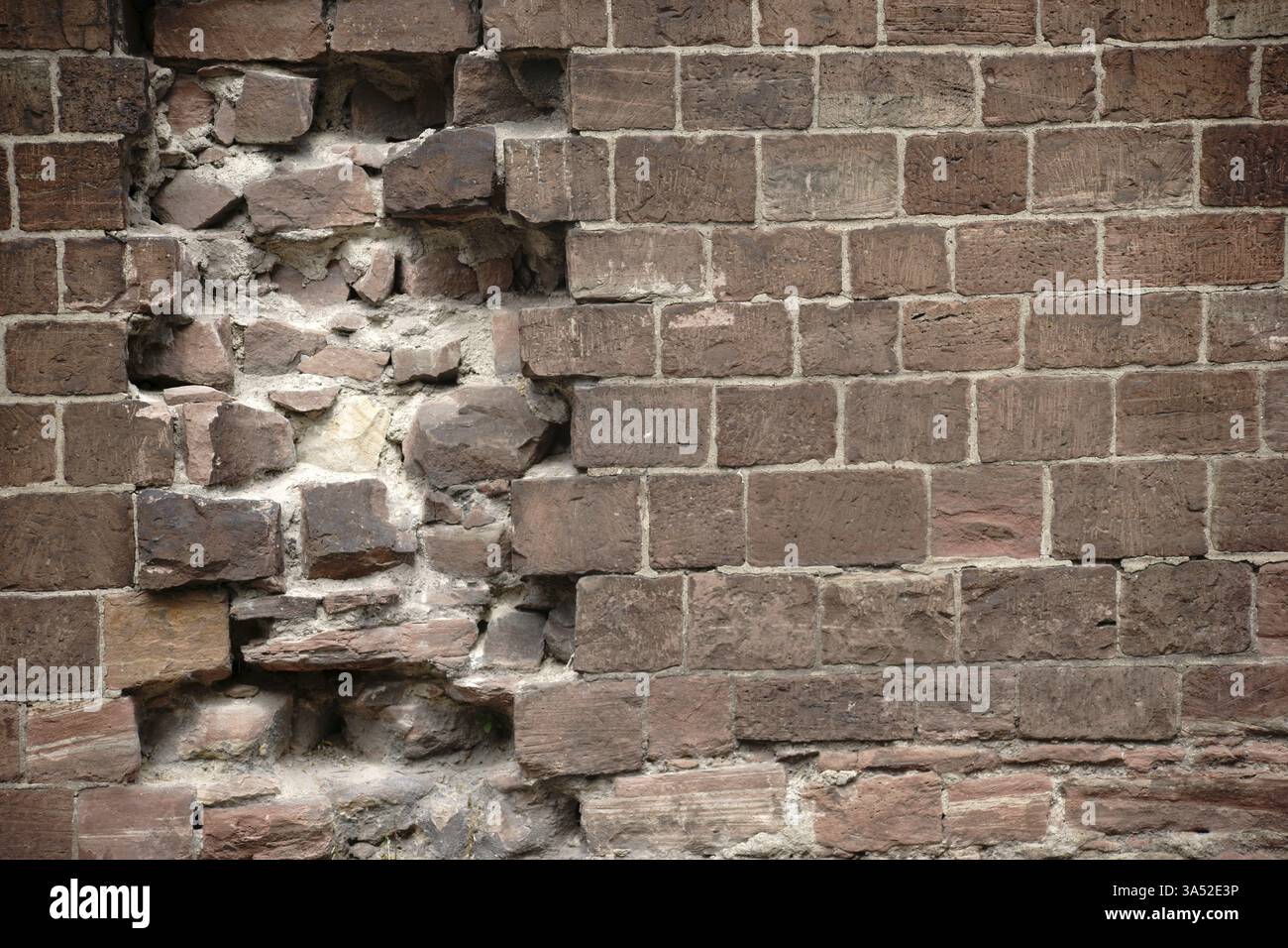 A wall of striking red bricks with damage and holes Stock Photo - Alamy