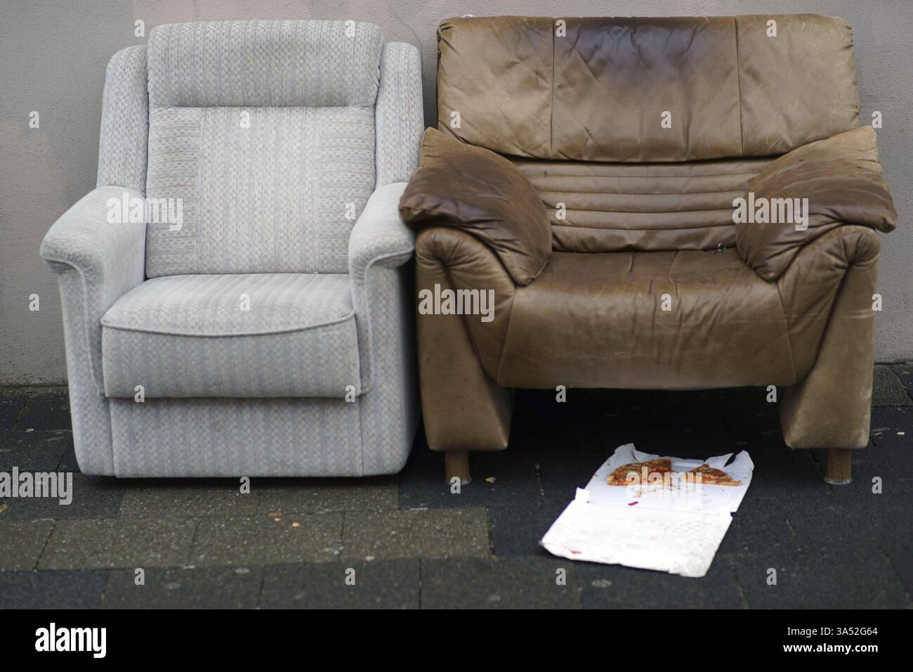 Two coffee chairs stand on a pavement with leftover food from homeless ...