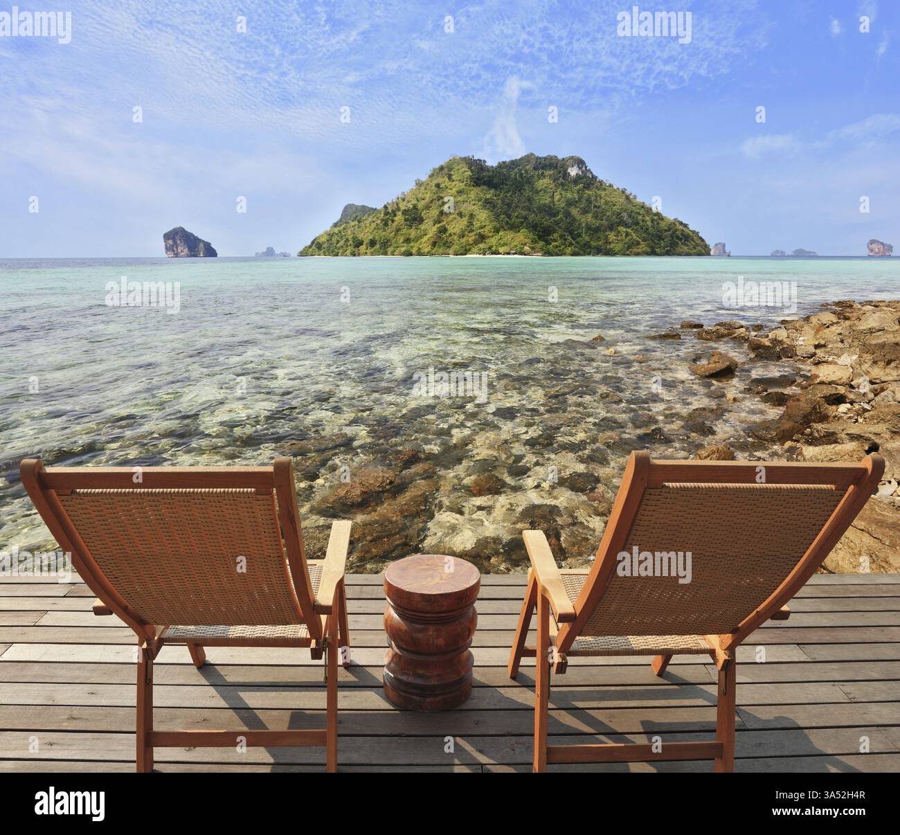 Two comfortable folding wooden chairs and a small side table. Through ...