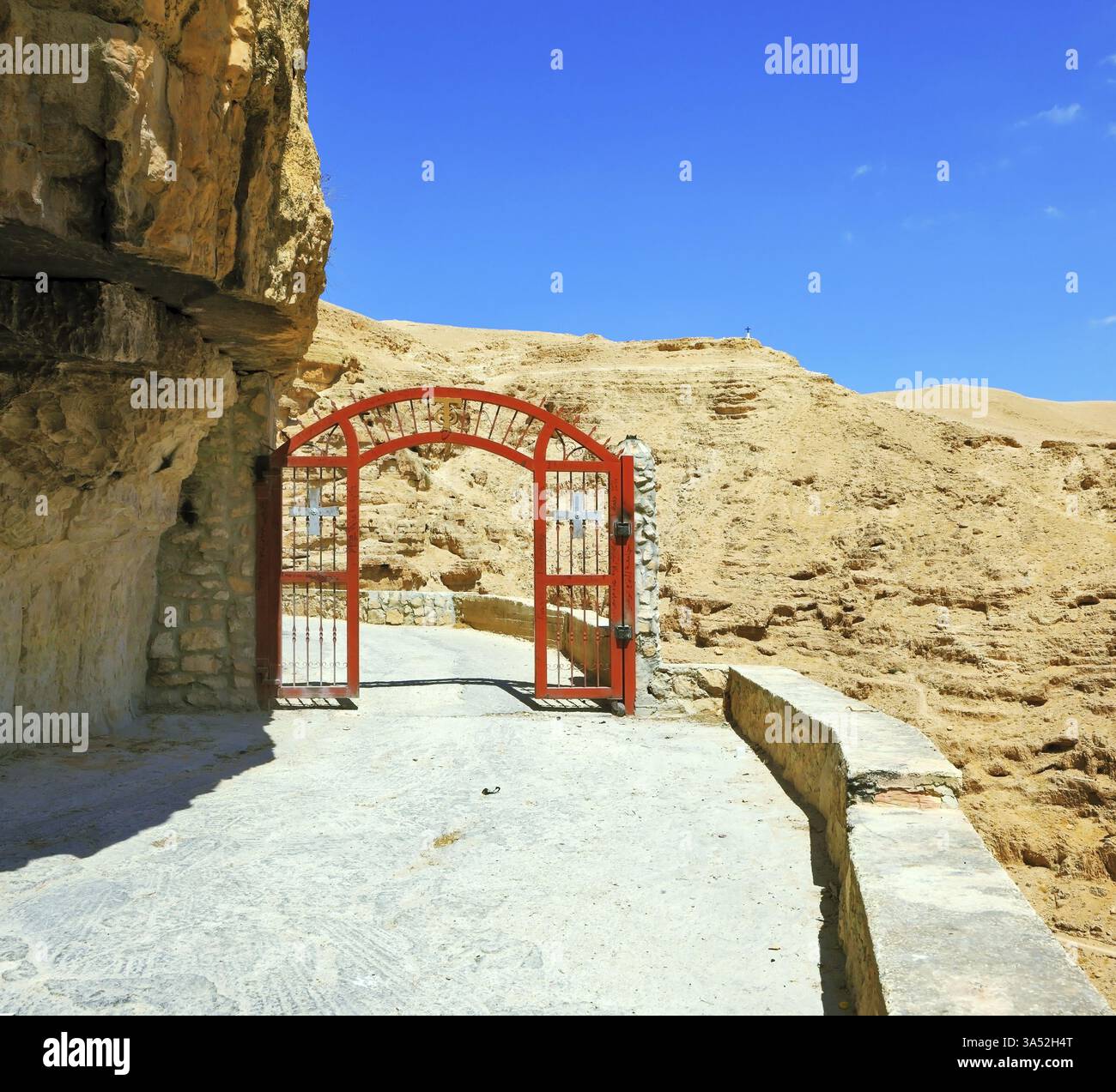 Decorative red gate with a cross on a mountain road going to the temple ...