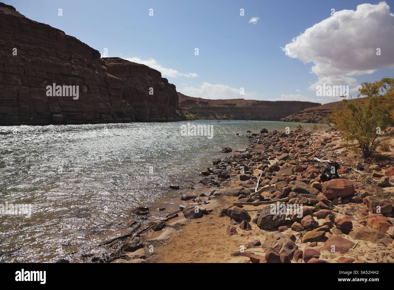 The stones in the shallows of the Colorado River in the red rocks of ...
