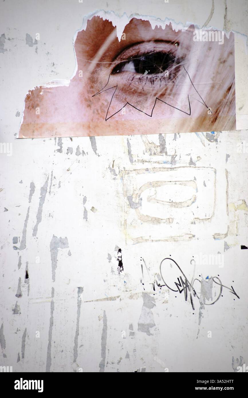 The close-up of a billboard with torn-off scraps of paper from posters ...