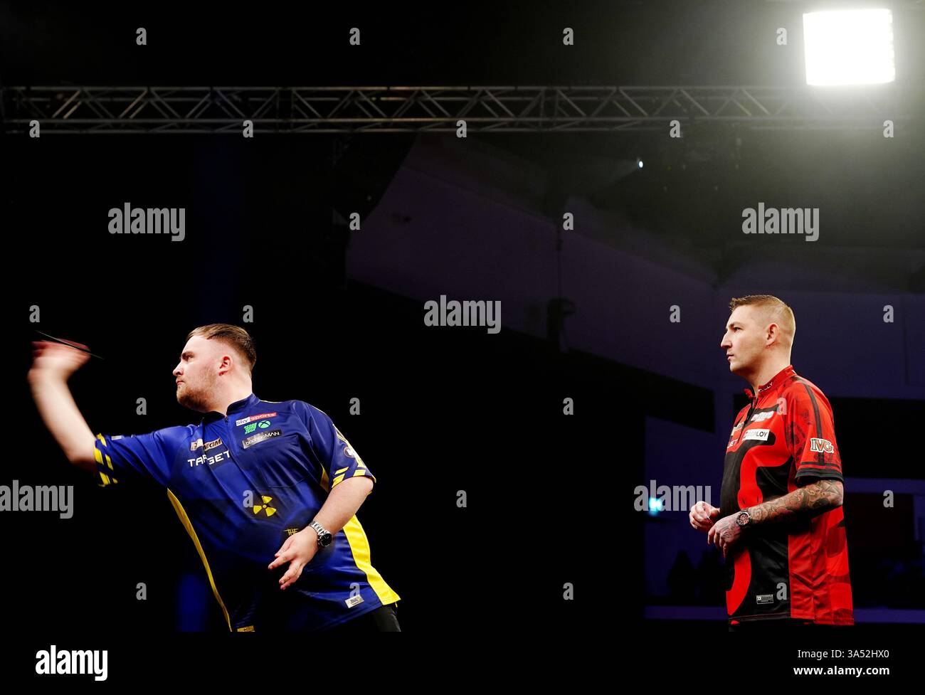 Luke Littler (left) in action against Nathan Aspinall during night ...