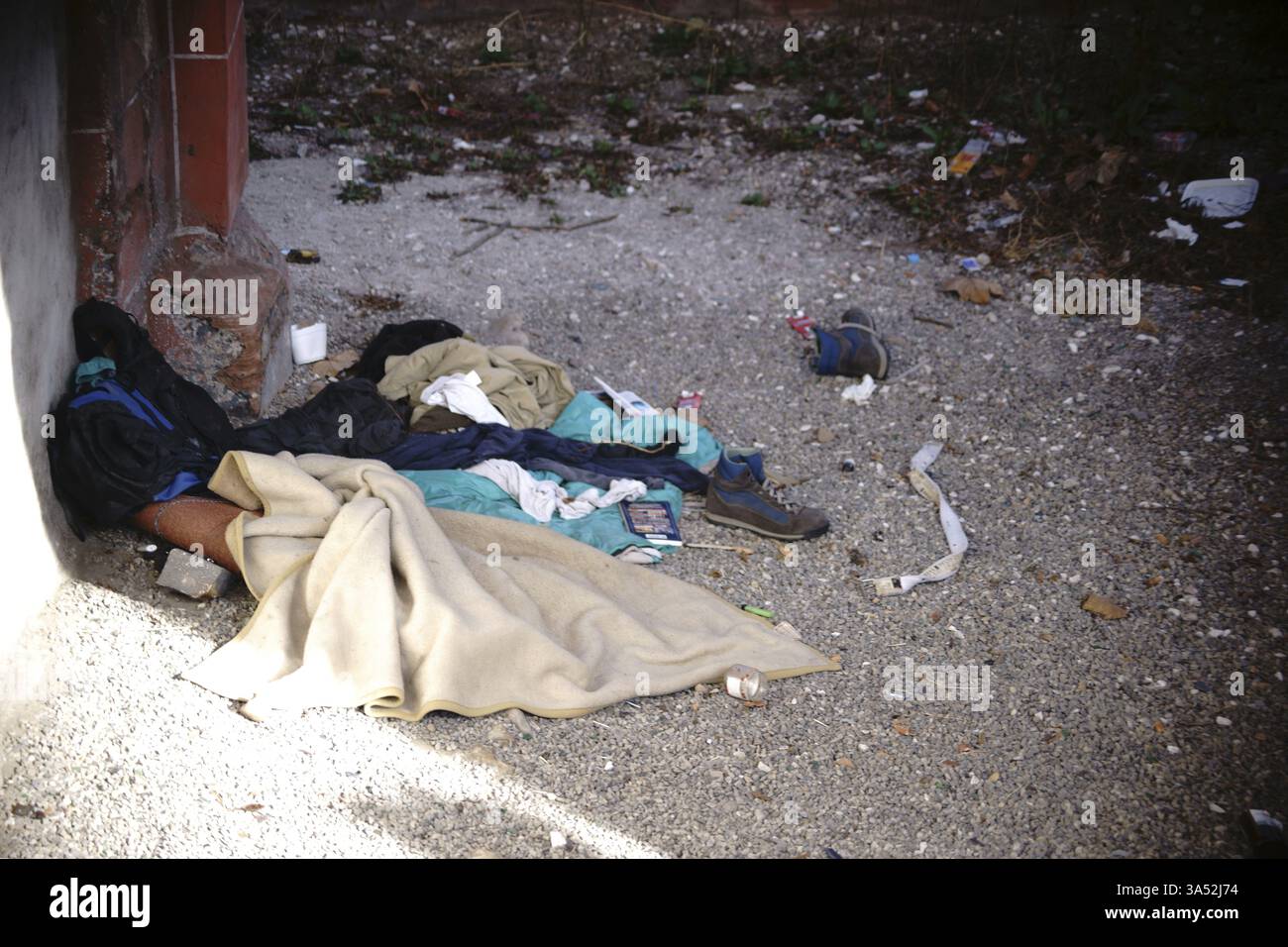 The sleeping place of a homeless person under a bridge with blankets ...