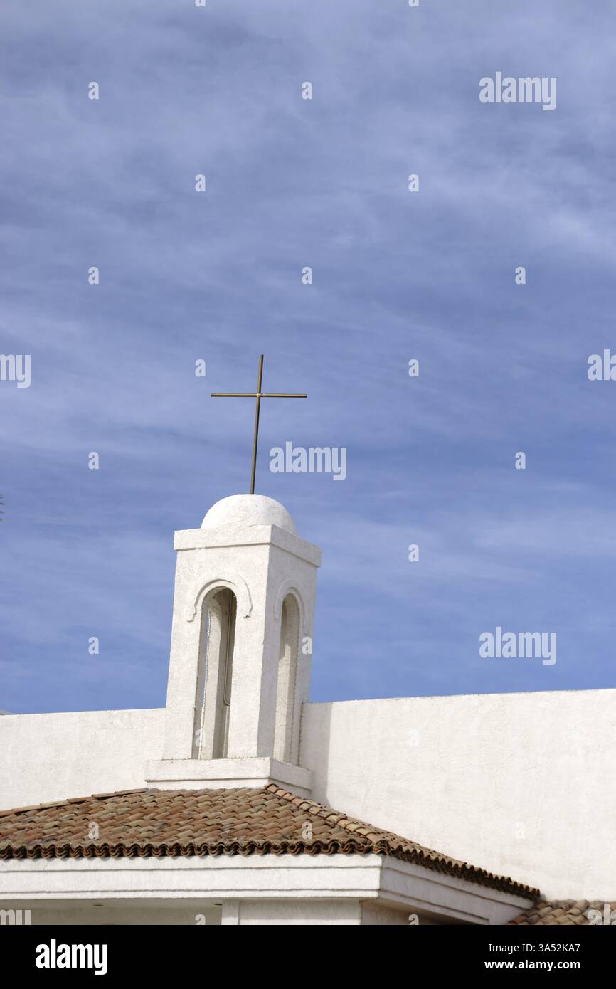 A Spanish-style church with white walls and simple construction with a ...