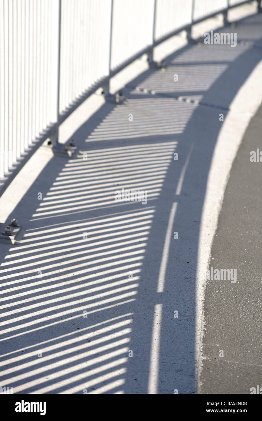 The metal railing of a bridge railing casts a shadow Stock Photo - Alamy