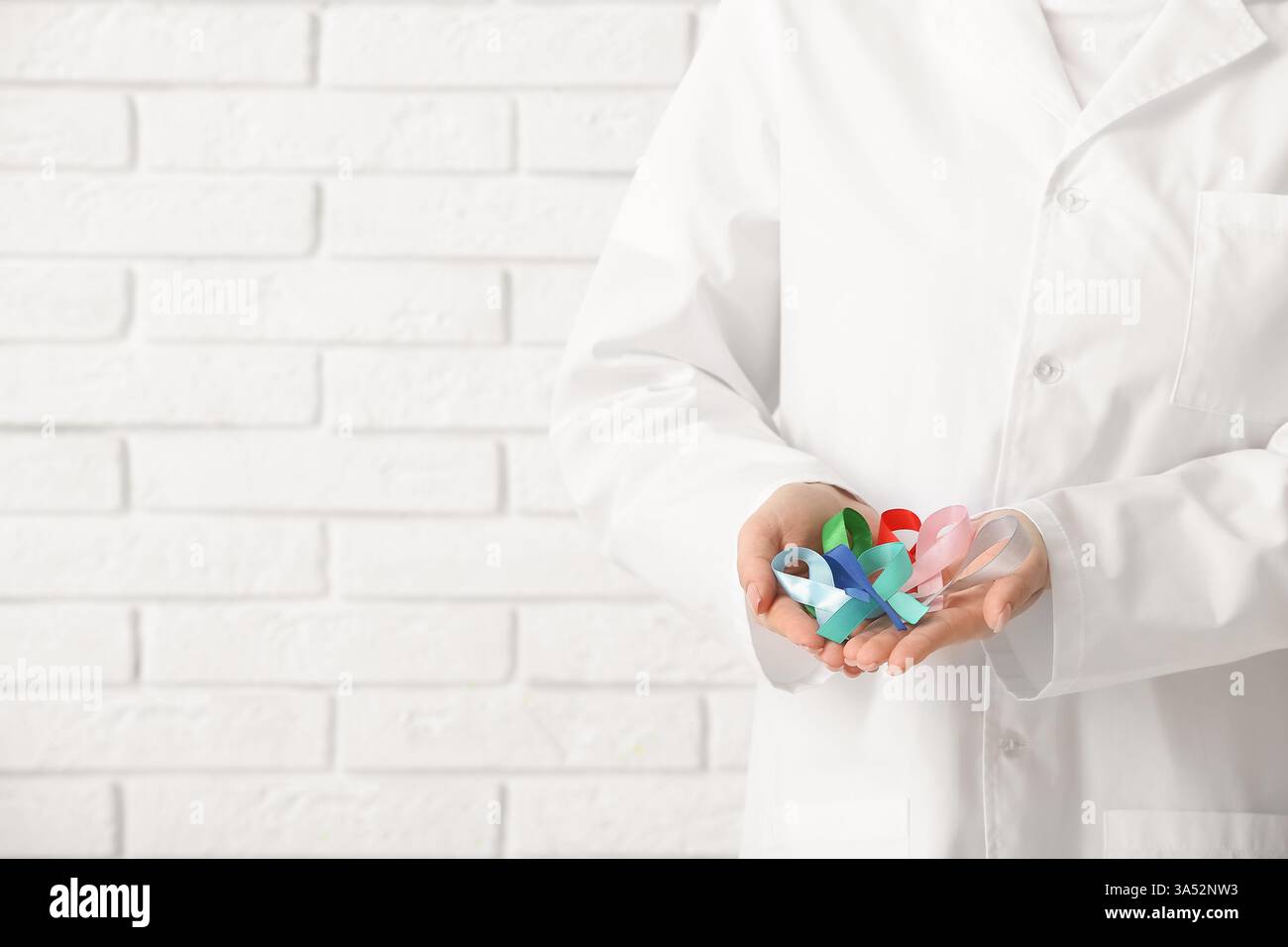 Female doctor with different awareness ribbons on white brick ...