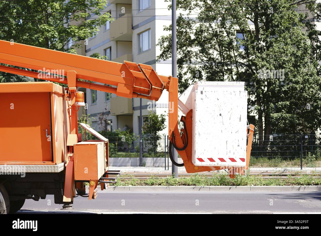 A lifting platform on a small lorry stands in front of a modern ...