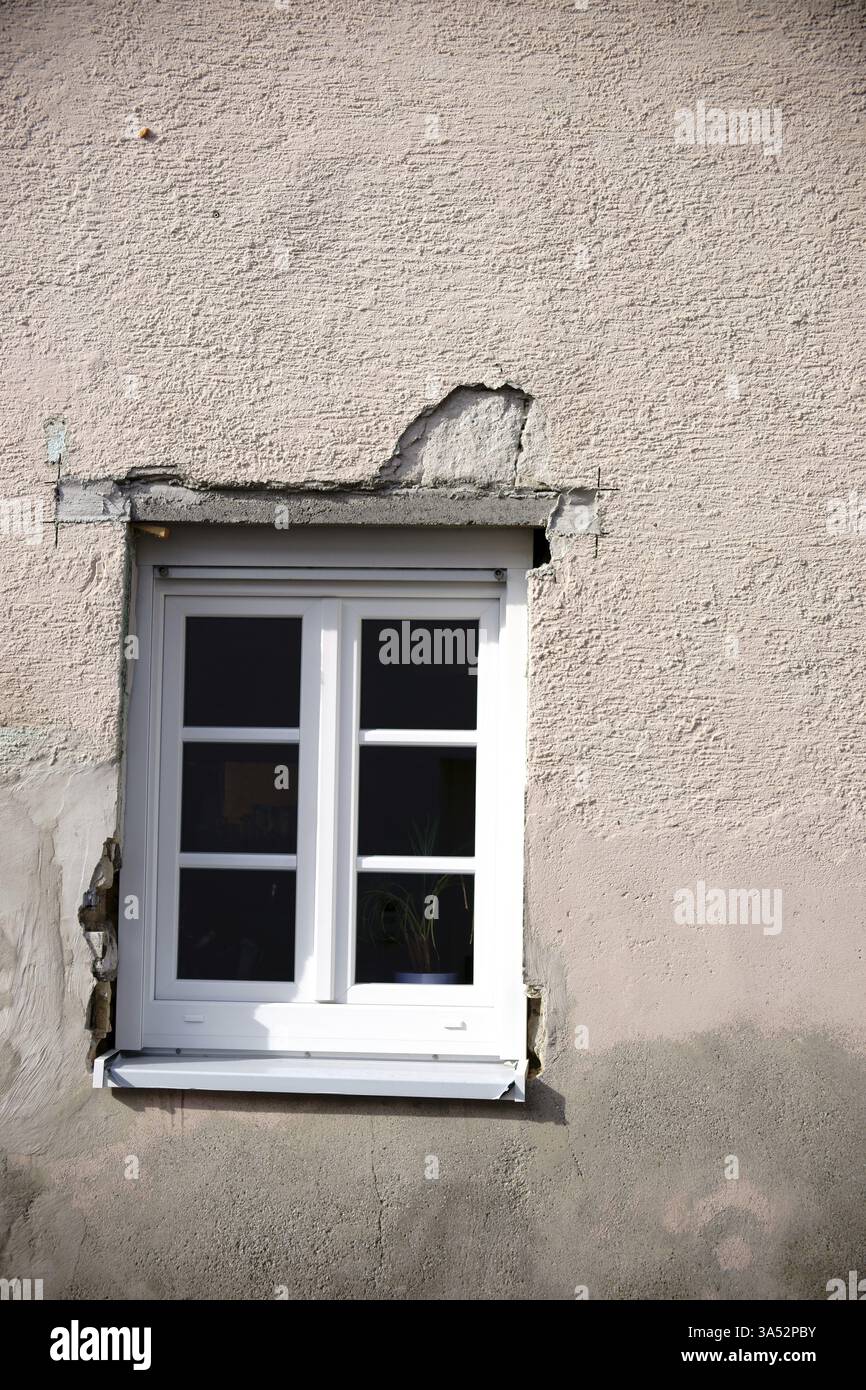 The facade of a house in need of renovation with a newly installed ...