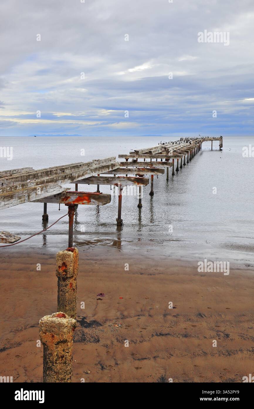 Old dilapidated pier in the Strait of Magellan. Corroded bearings and ...
