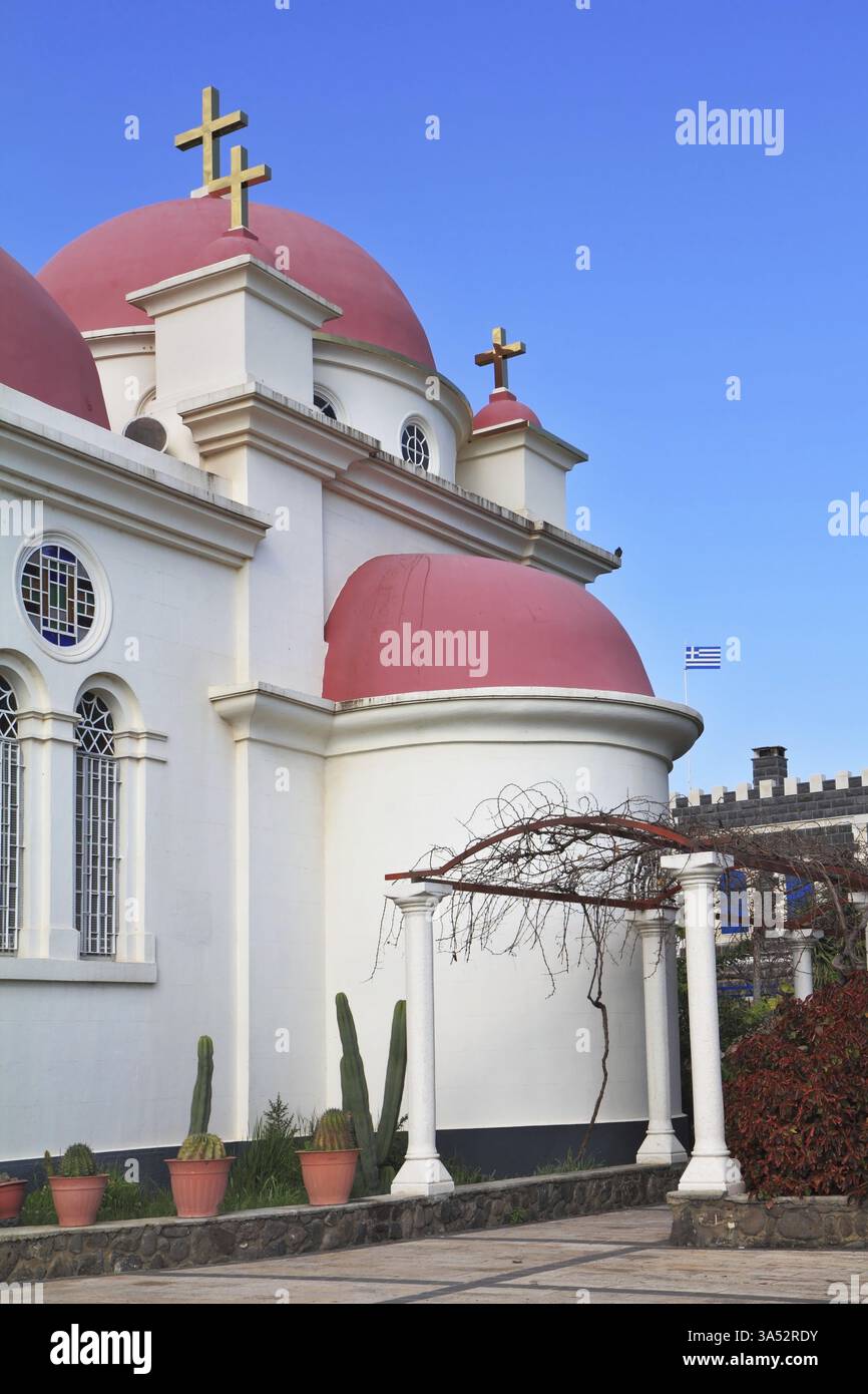Bright pink dome, whitewashed walls of the holy temple on the shore of ...