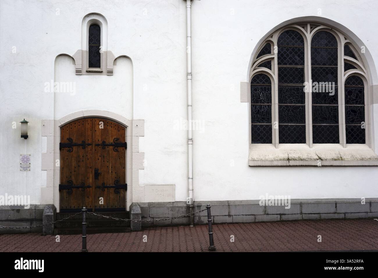 A heavy wooden church door in the bleached facade of a Protestant ...