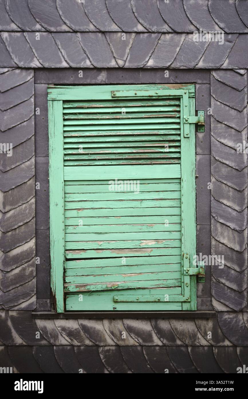 A rotten shutter of a window on a striking facade made of grey shingles Stock Photo - Alamy