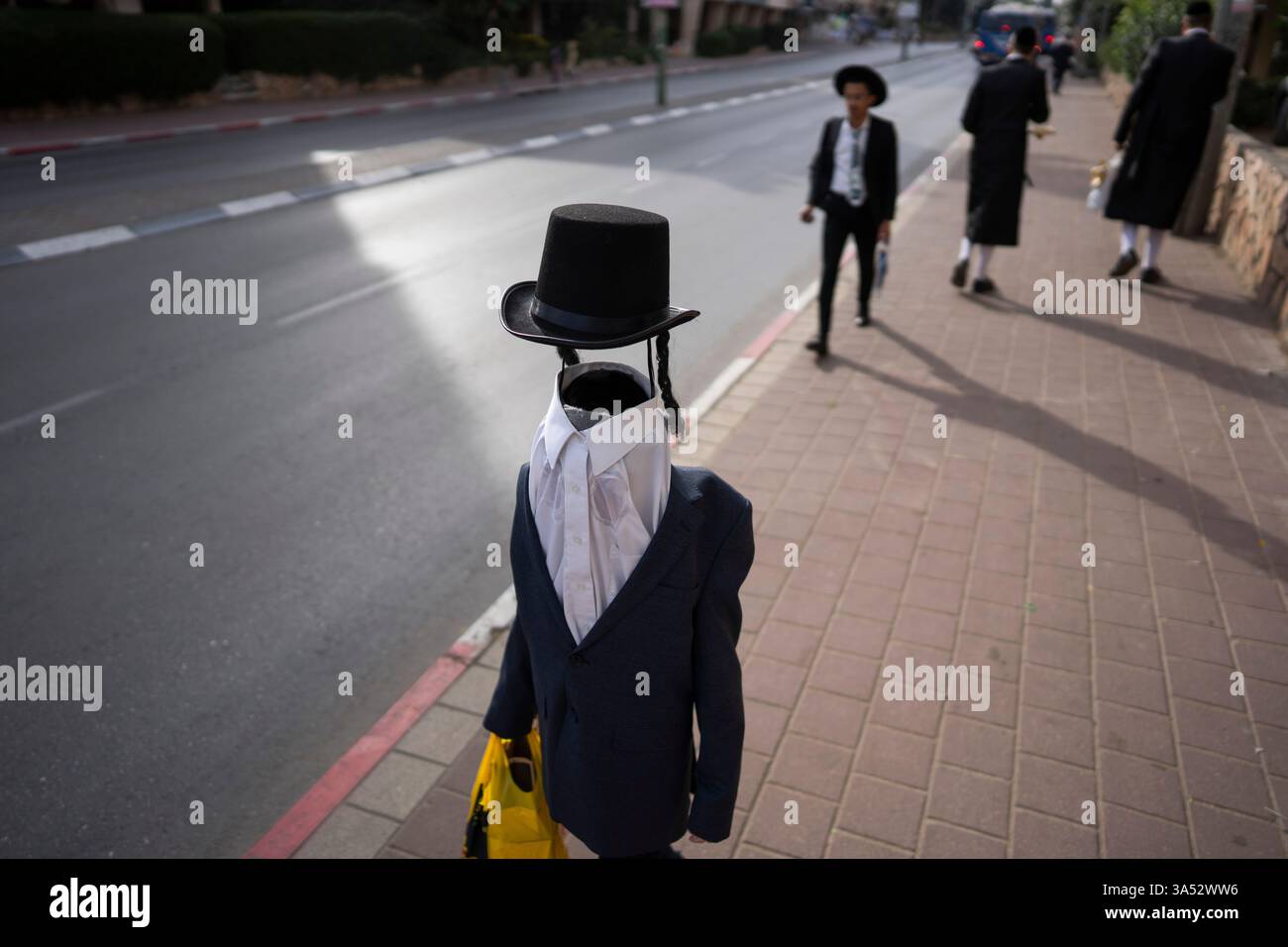 An ultra-Orthodox Jewish child walks through the streets in costume ...