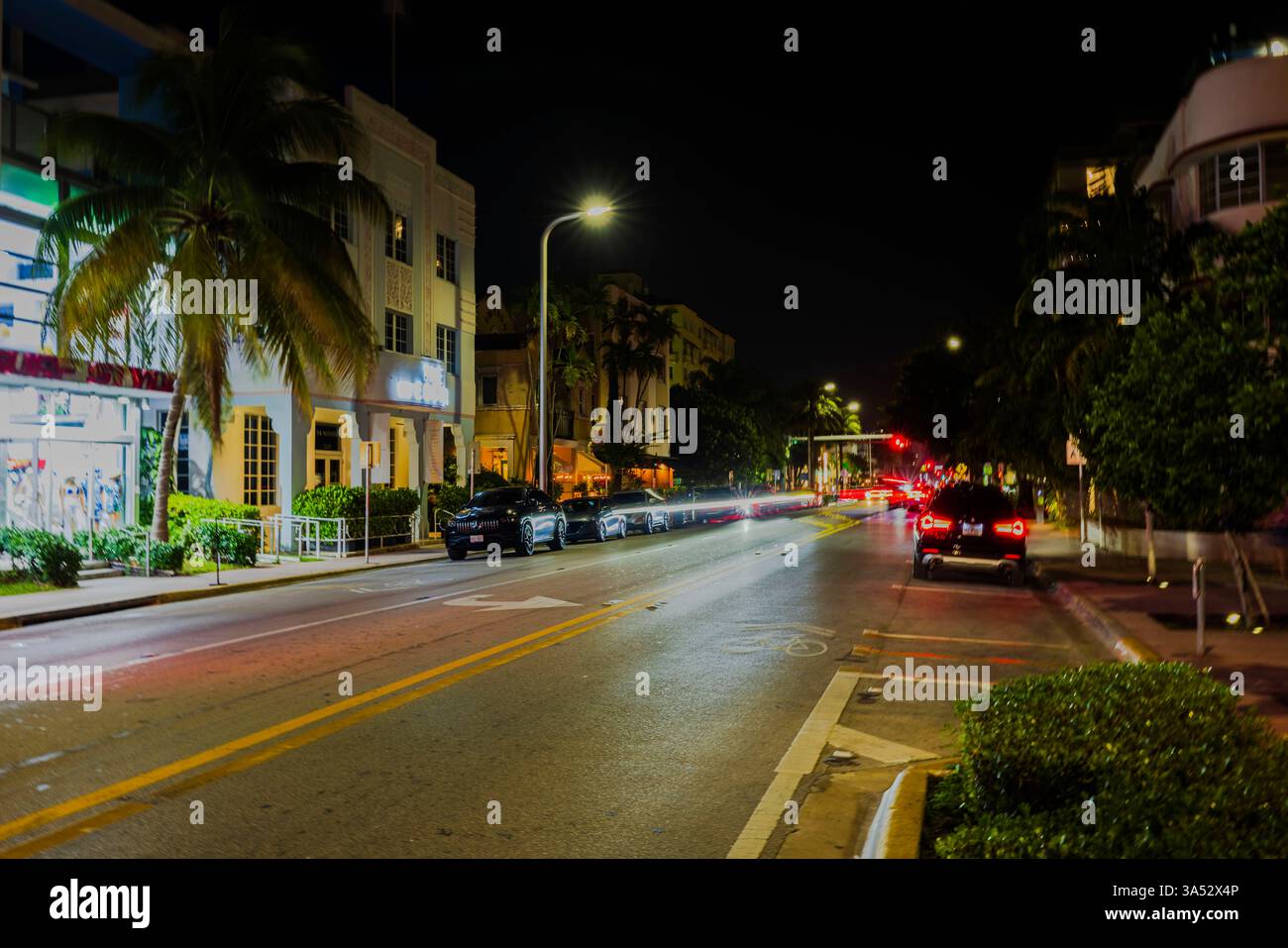 Collins Avenue at night in Miami Beach with car headlights creating ...