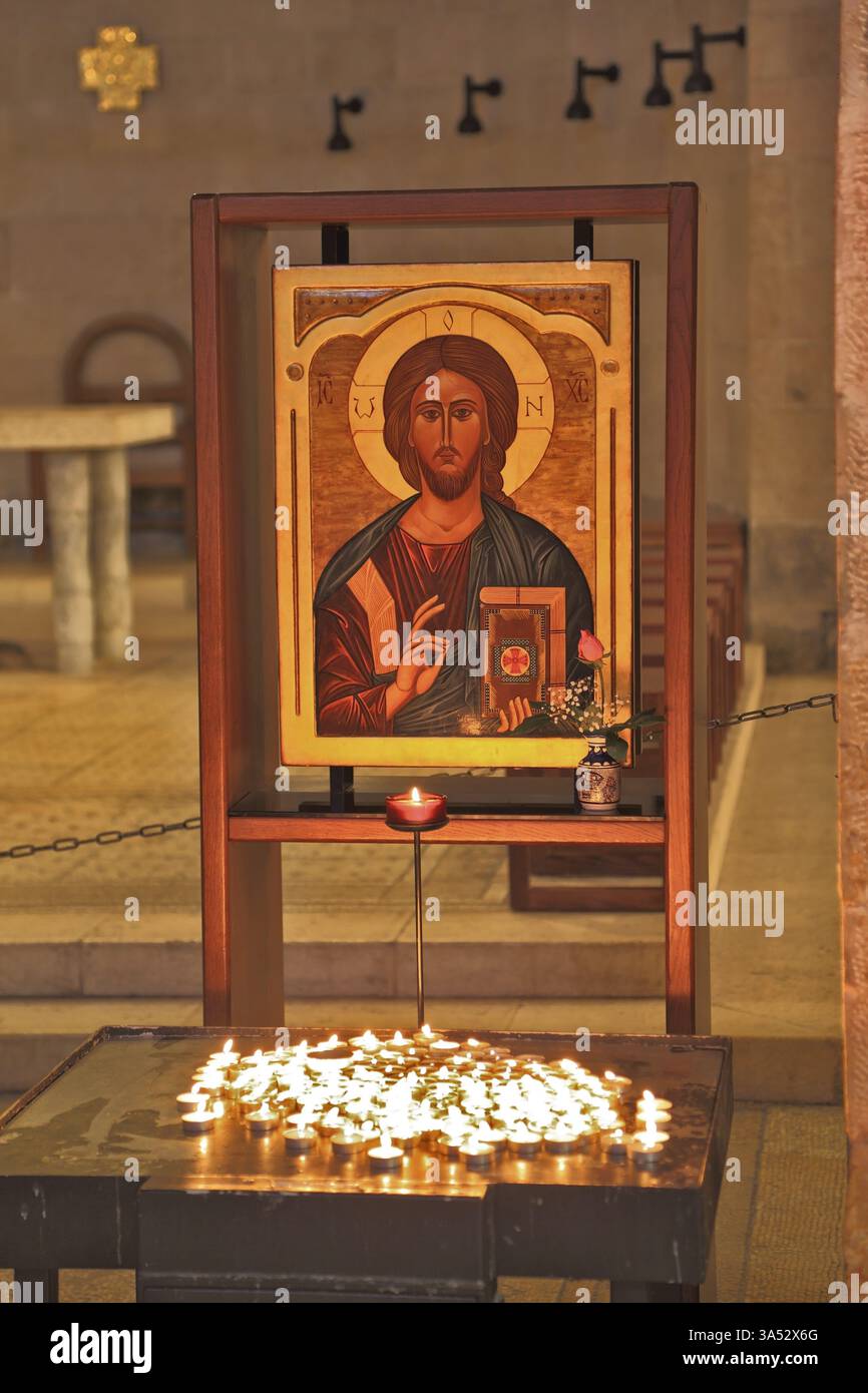 Magnificent old icon of Jesus Christ, and a table with burning candles ...