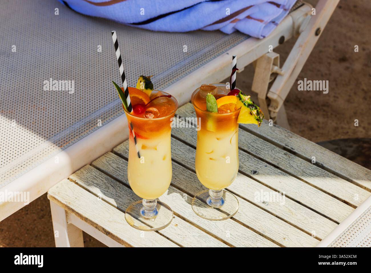 Two tropical Mai Tai cocktails with pineapple and cherry garnish served ...