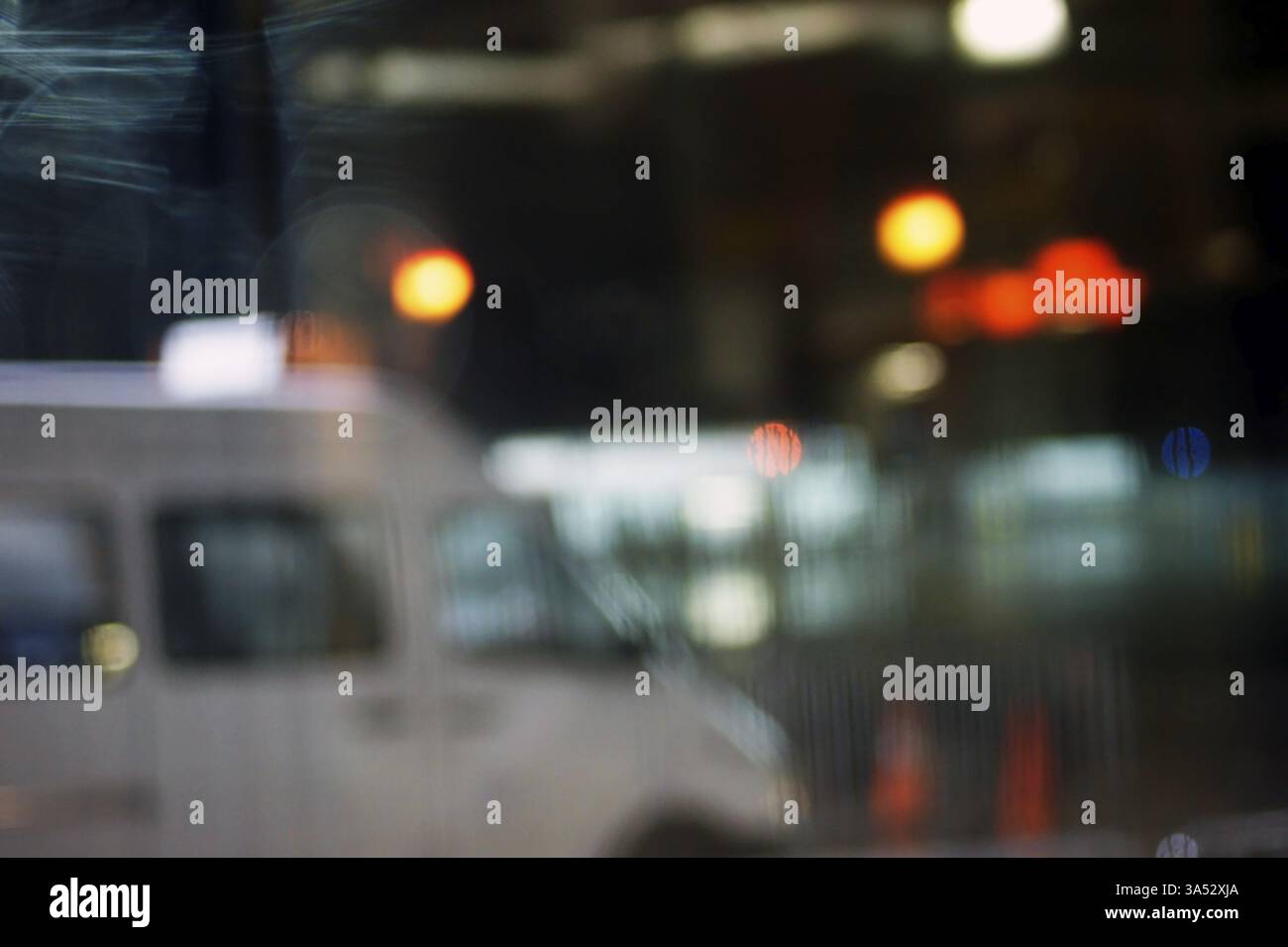 Abstract and blurred brake lights and light circles behind a window ...