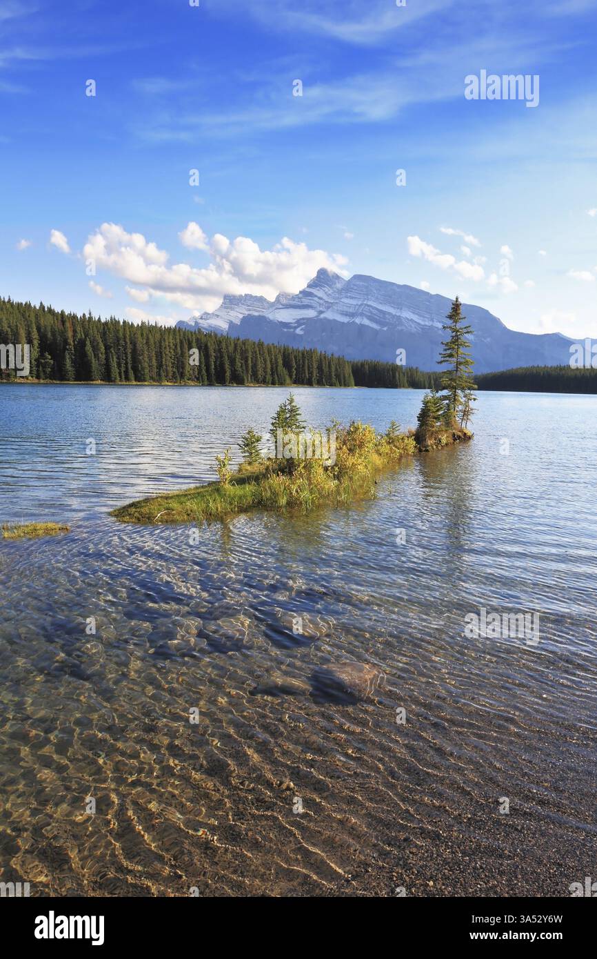A tiny island in a lake coats. Quiet shallow lake in Banff National ...