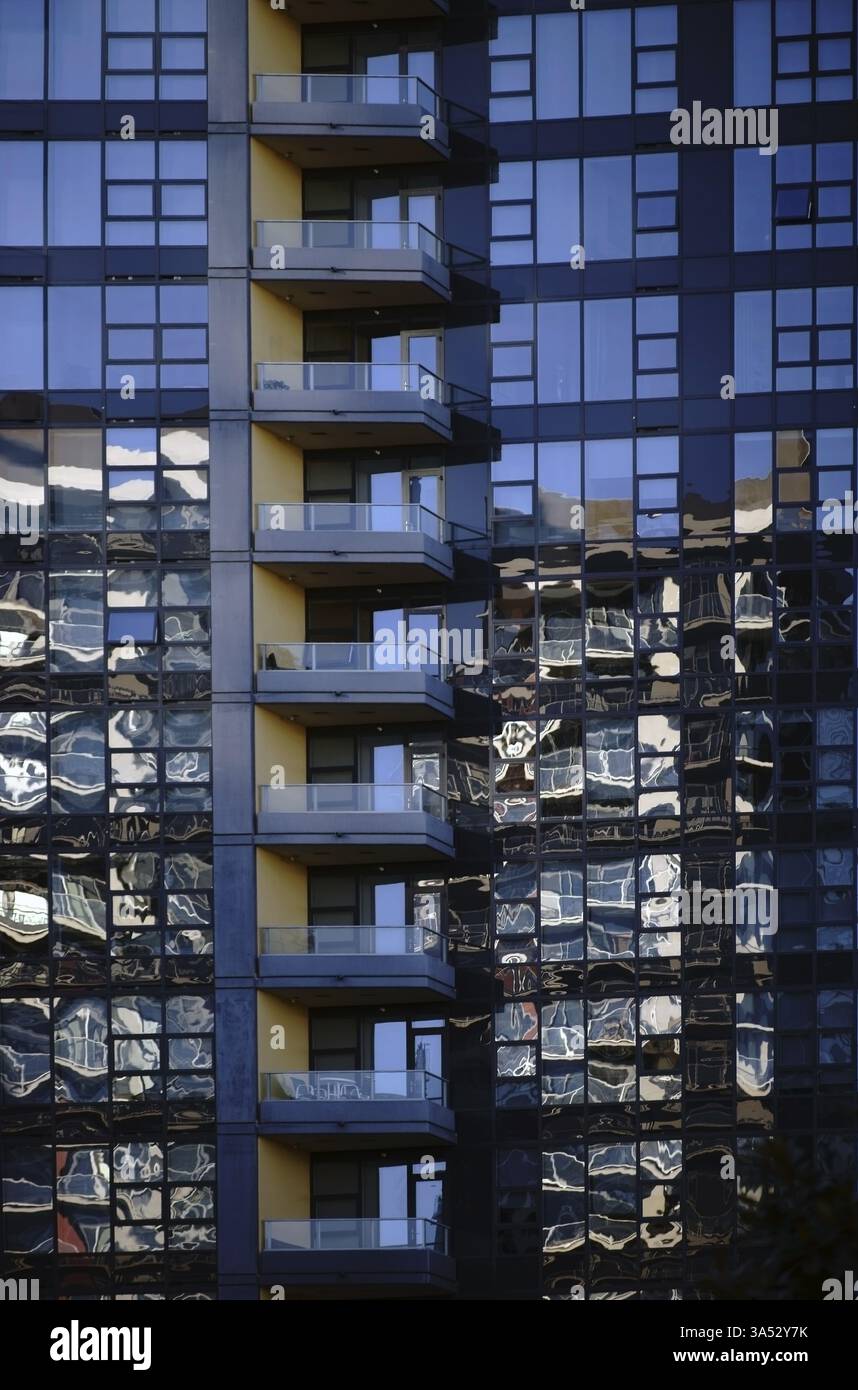 Abstract reflections of surrounding buildings in the glass facade of a ...