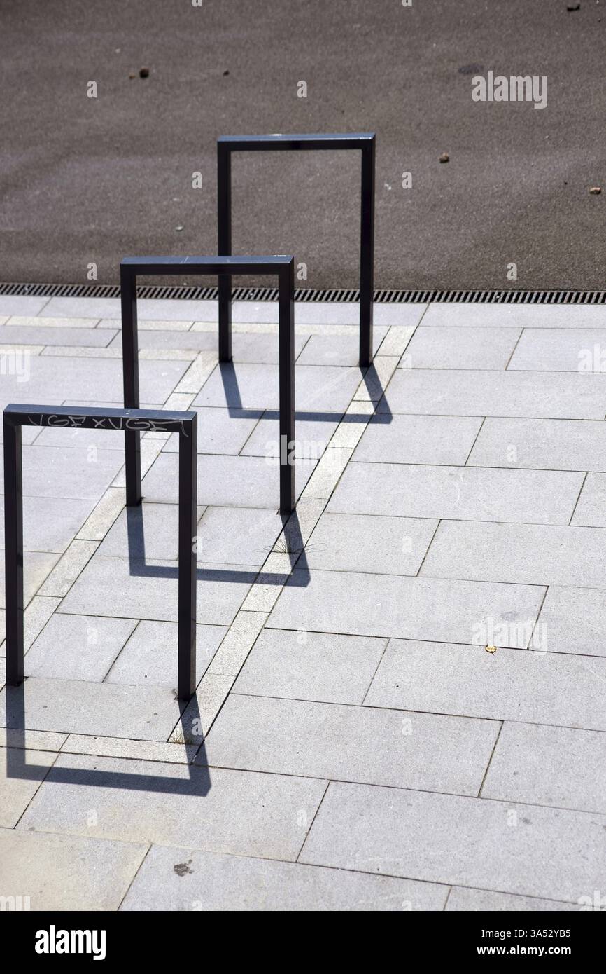 Modern, angular bicycle stands arranged in rows cast shadows on the ...