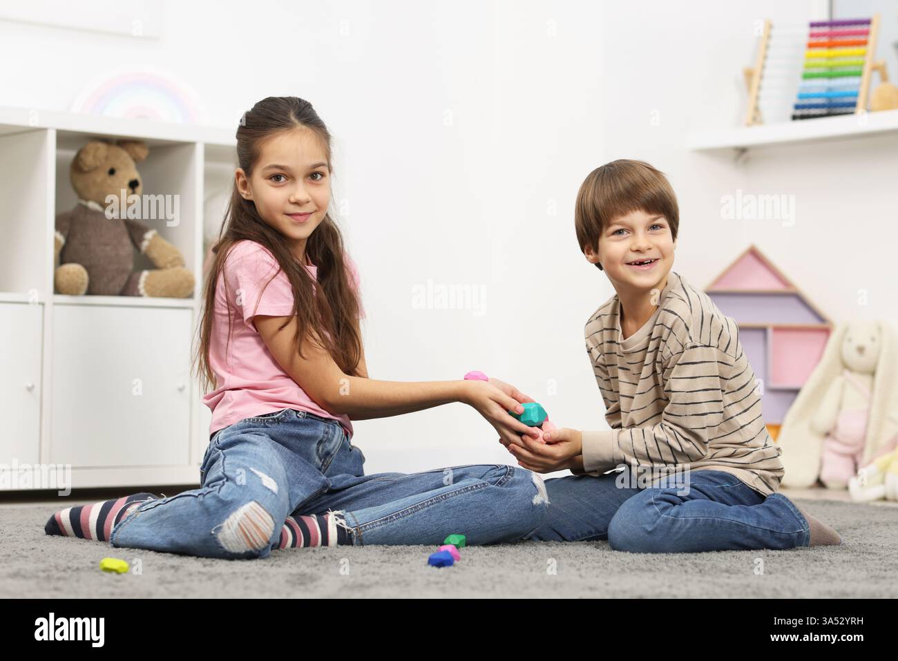 Children playing with balancing stones on floor indoors Stock Photo - Alamy