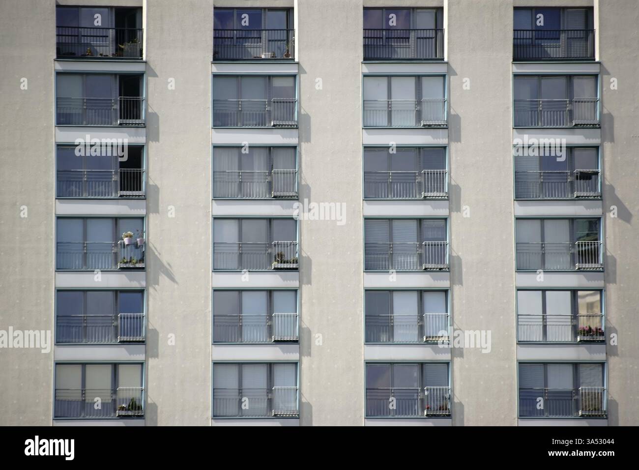 A multi-storey residential building with terraced windows and railings ...