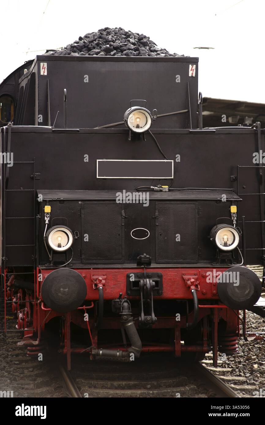 The front view of an old steam locomotive with coal to heat the steam ...