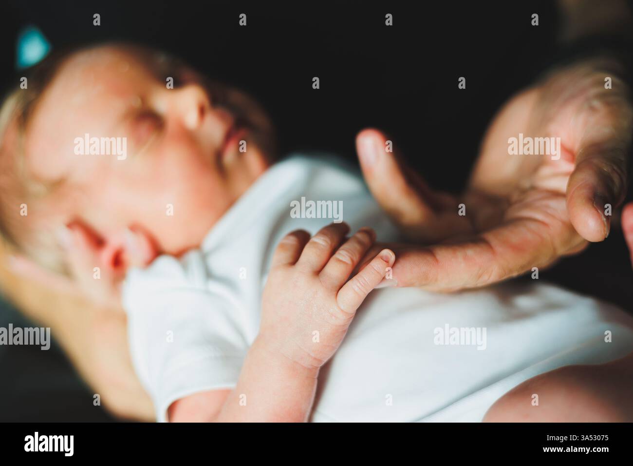 This image captures a serene moment of a loving parent cradling their ...