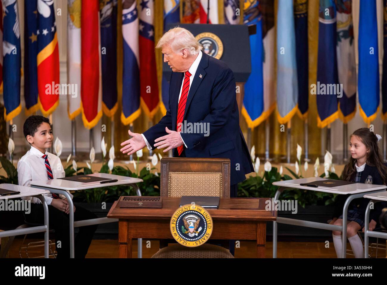 US President Donald Trump prepares to sign an executive order aimed at ...
