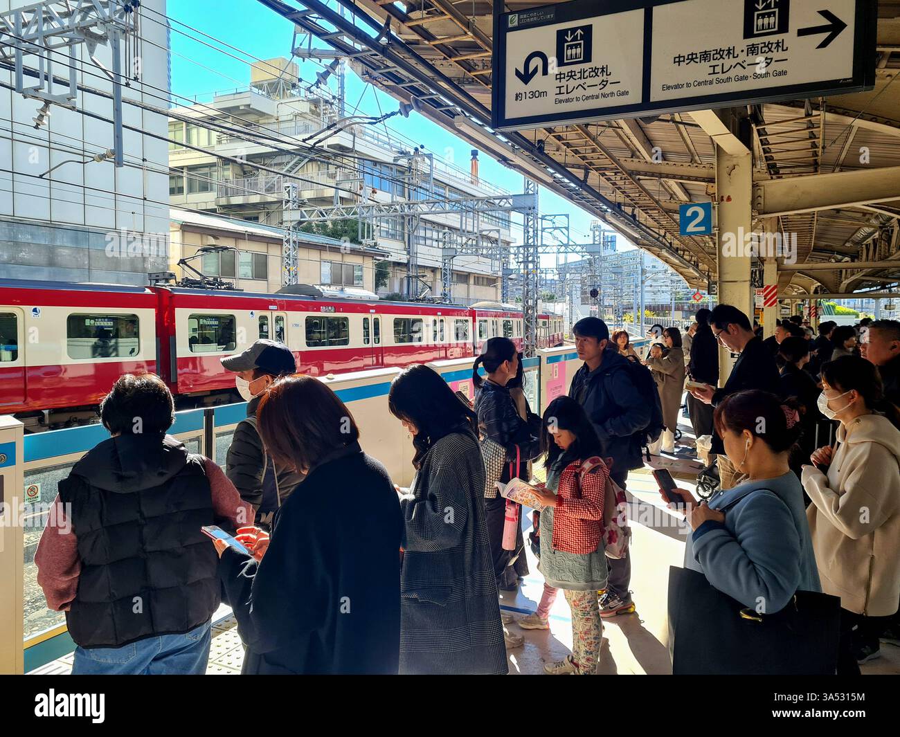 A crowded railway station platform in Yokohama with lots of passengers waiting for a train Stock ...